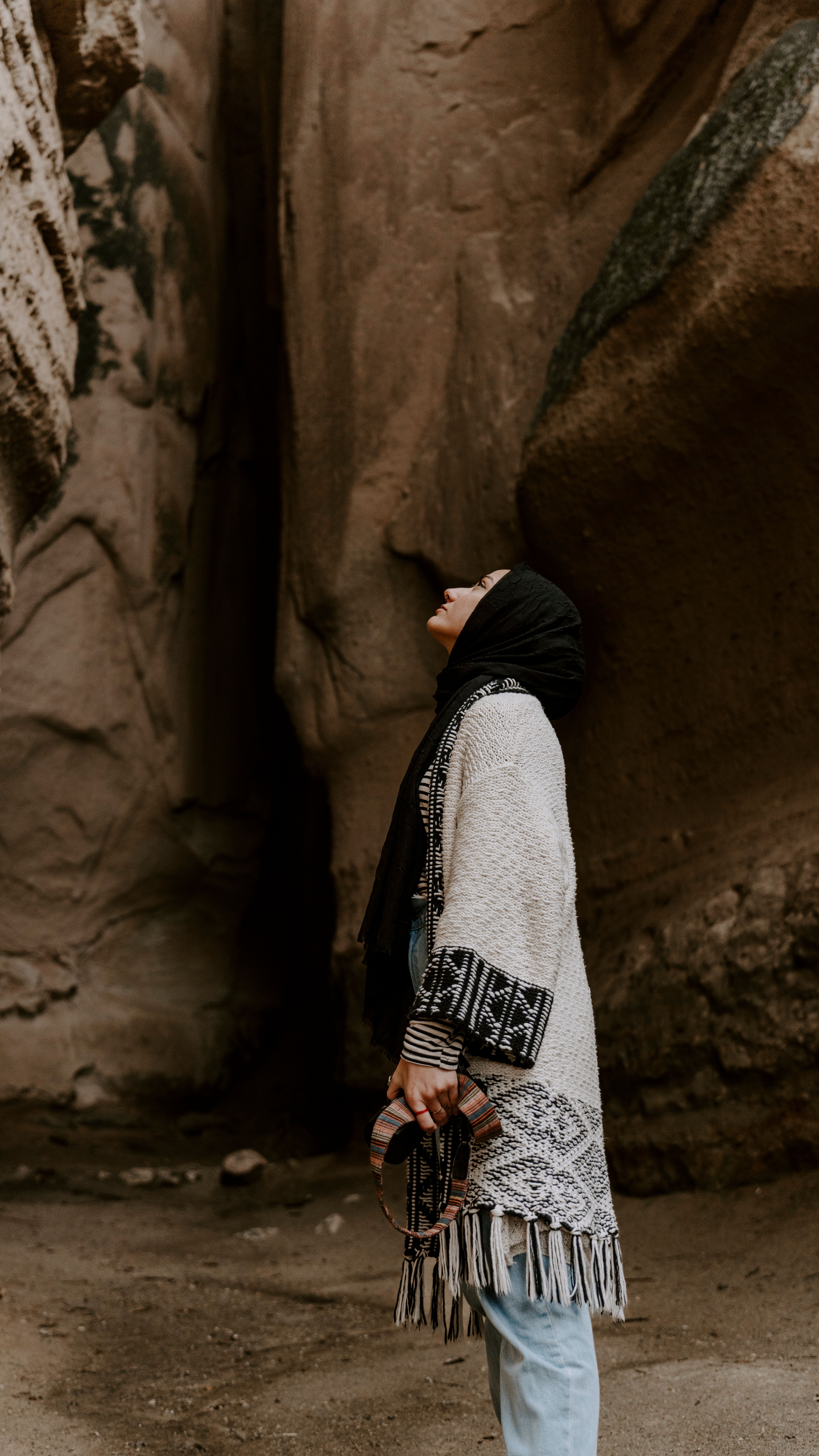 Young Woman Standing in front of a Cliff and Looking up · Free Stock Photo