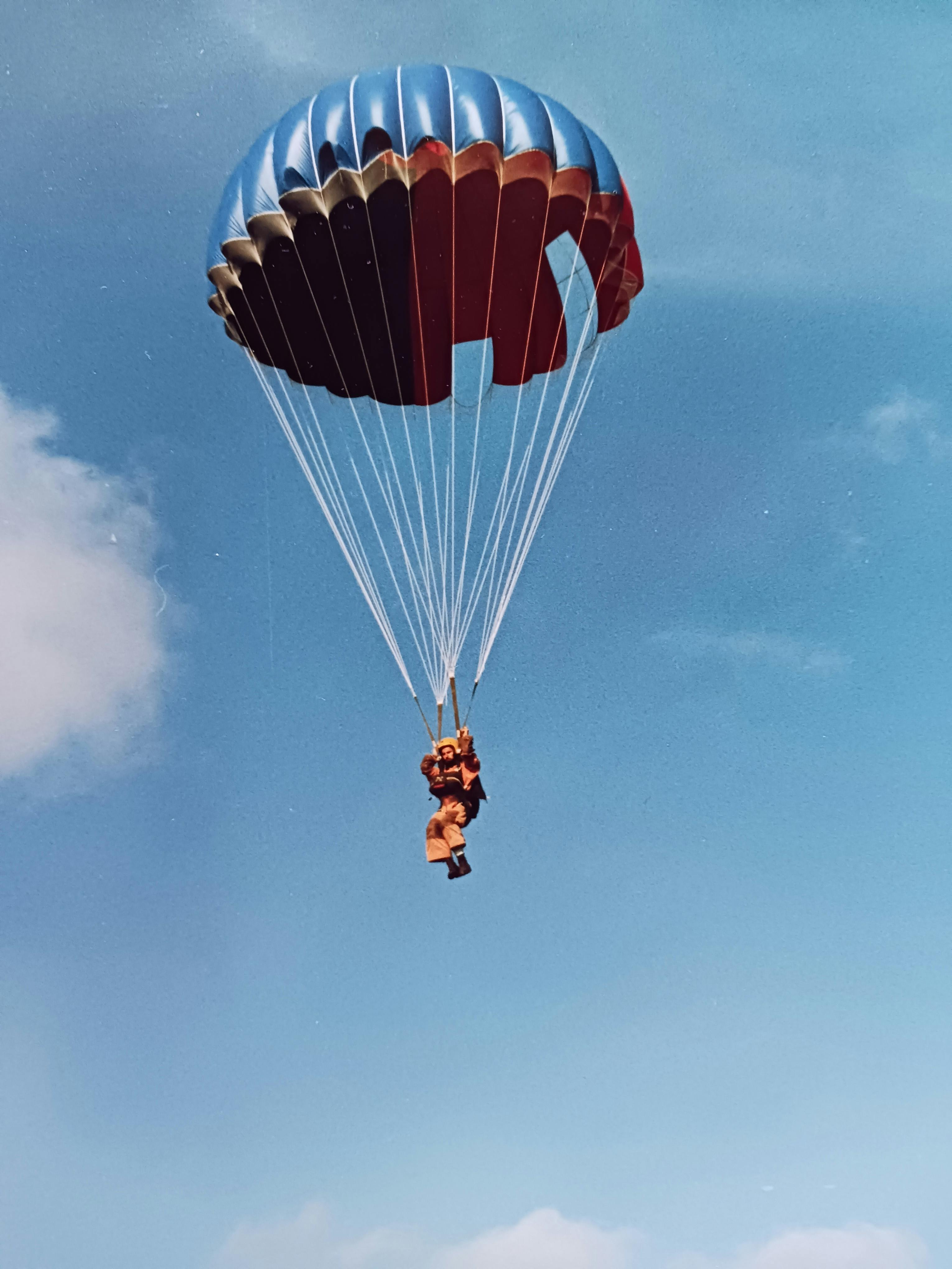 Person Flying on Parachute in Blue Sky · Free Stock Photo