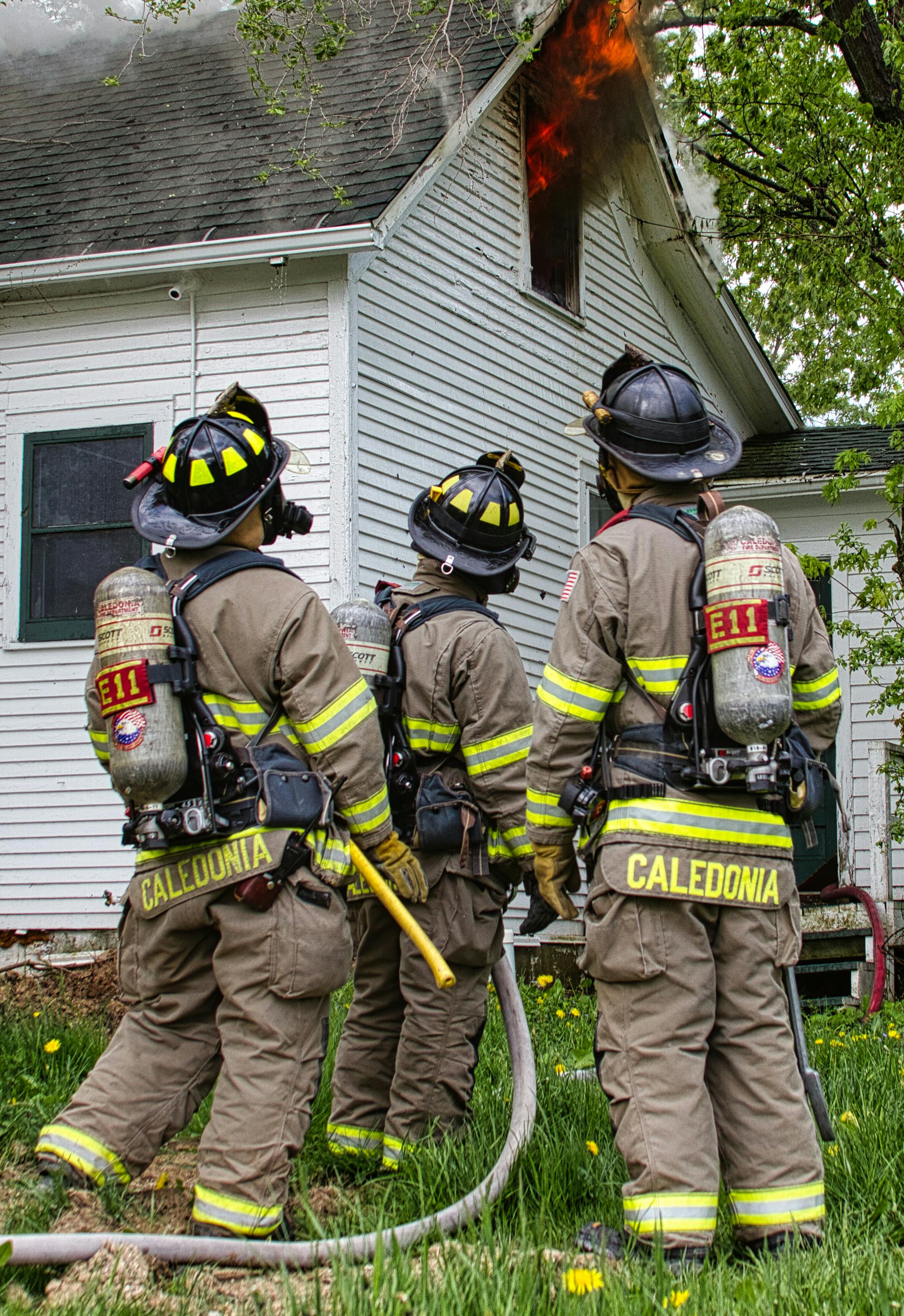 Team of Firefighters Looking at a Burning House · Free Stock Photo