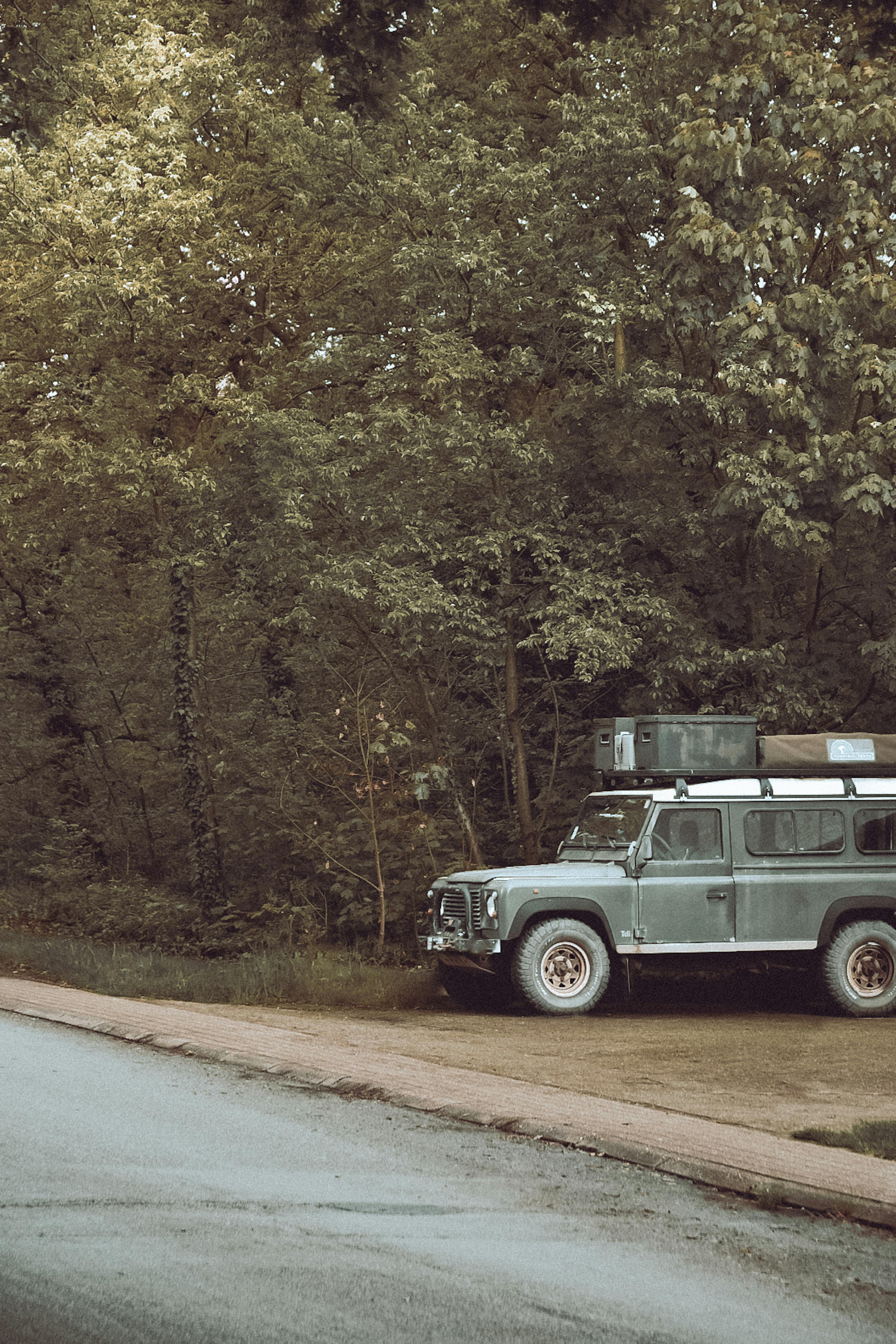Land Rover Defender on a Roadside Stop in the Forest · Free Stock Photo