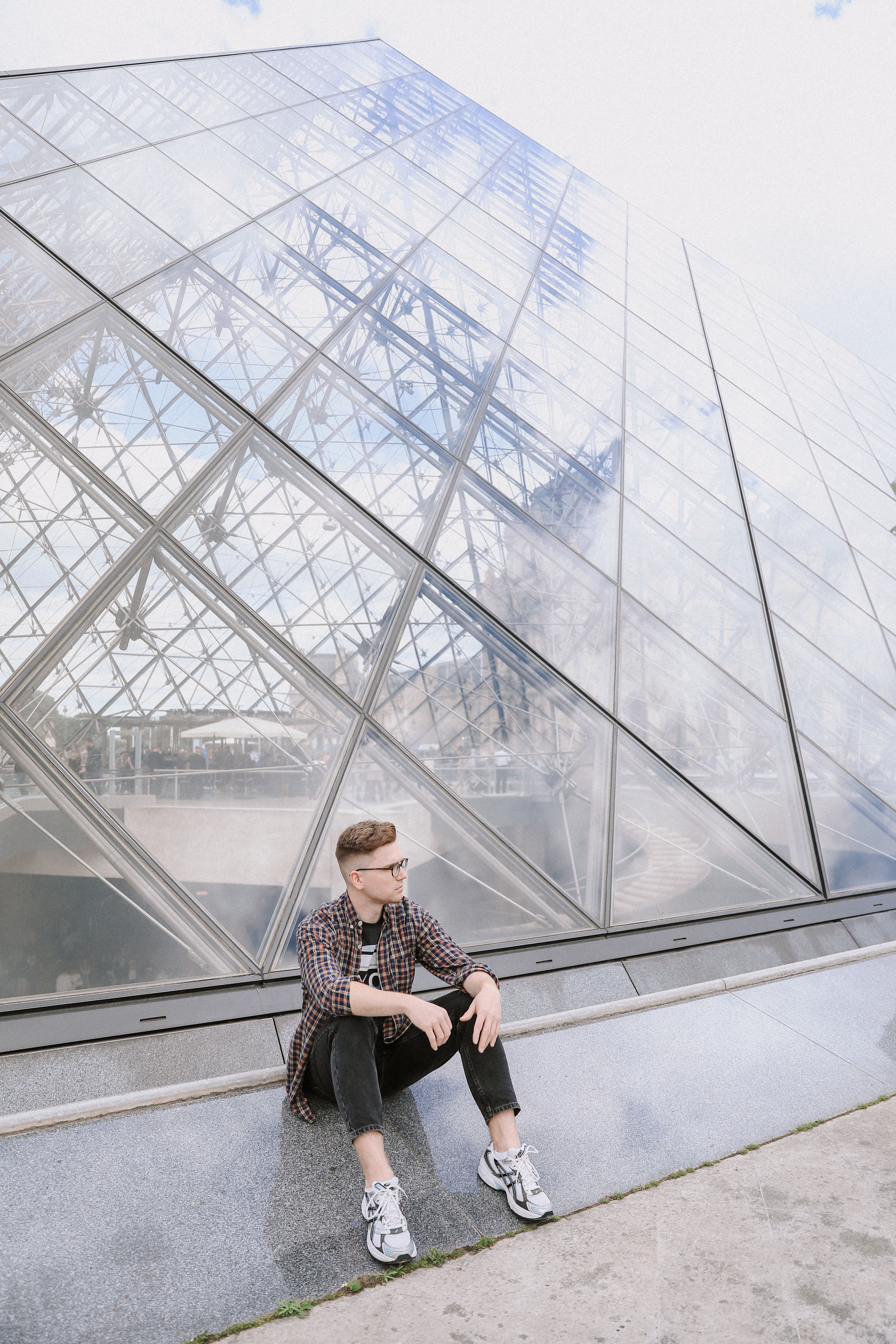 Man Sitting by Louvre Pyramid · Free Stock Photo