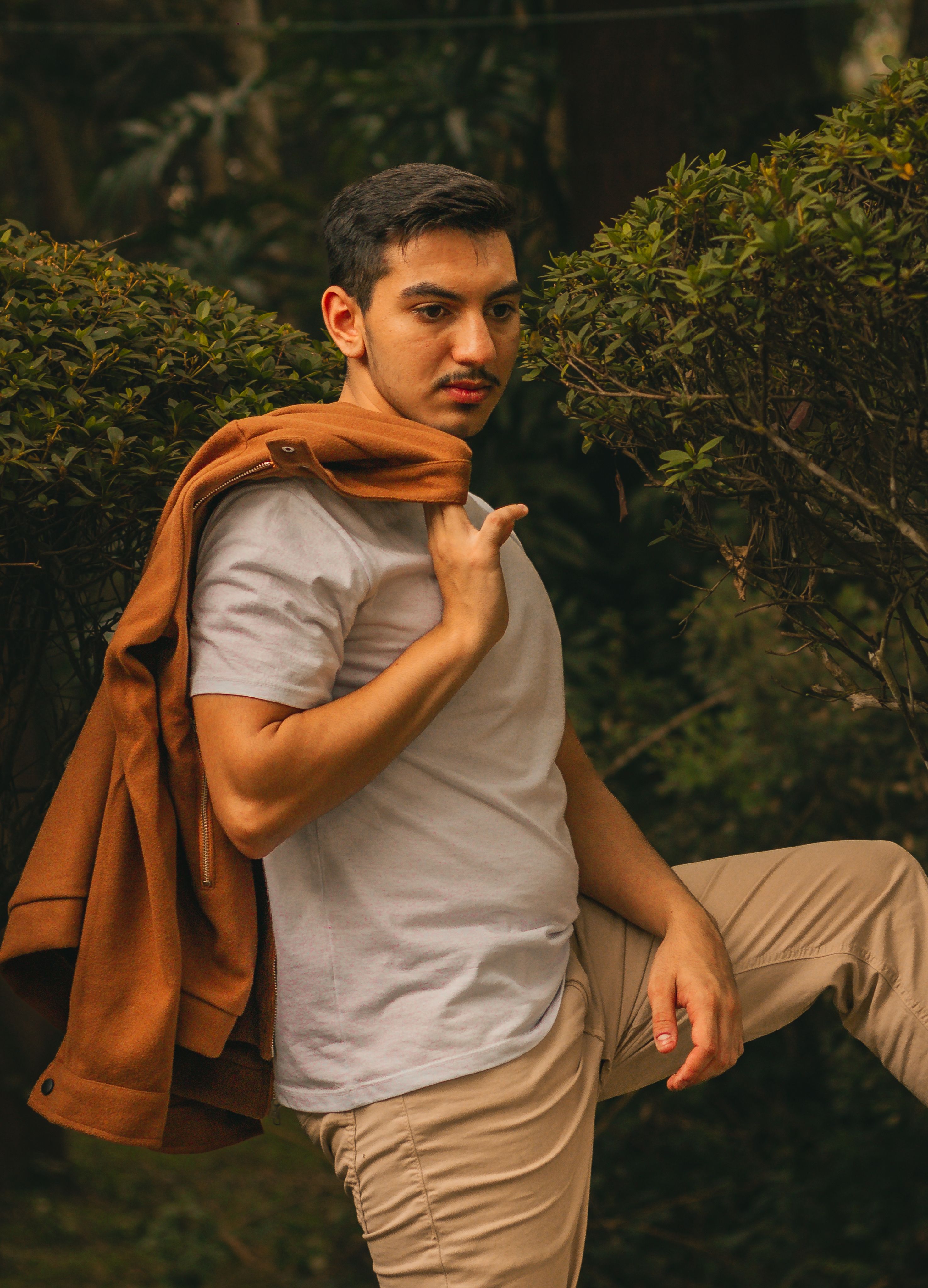 Model in a T-shirt and Suit Jacket Slung Over His Shoulder Standing in ...