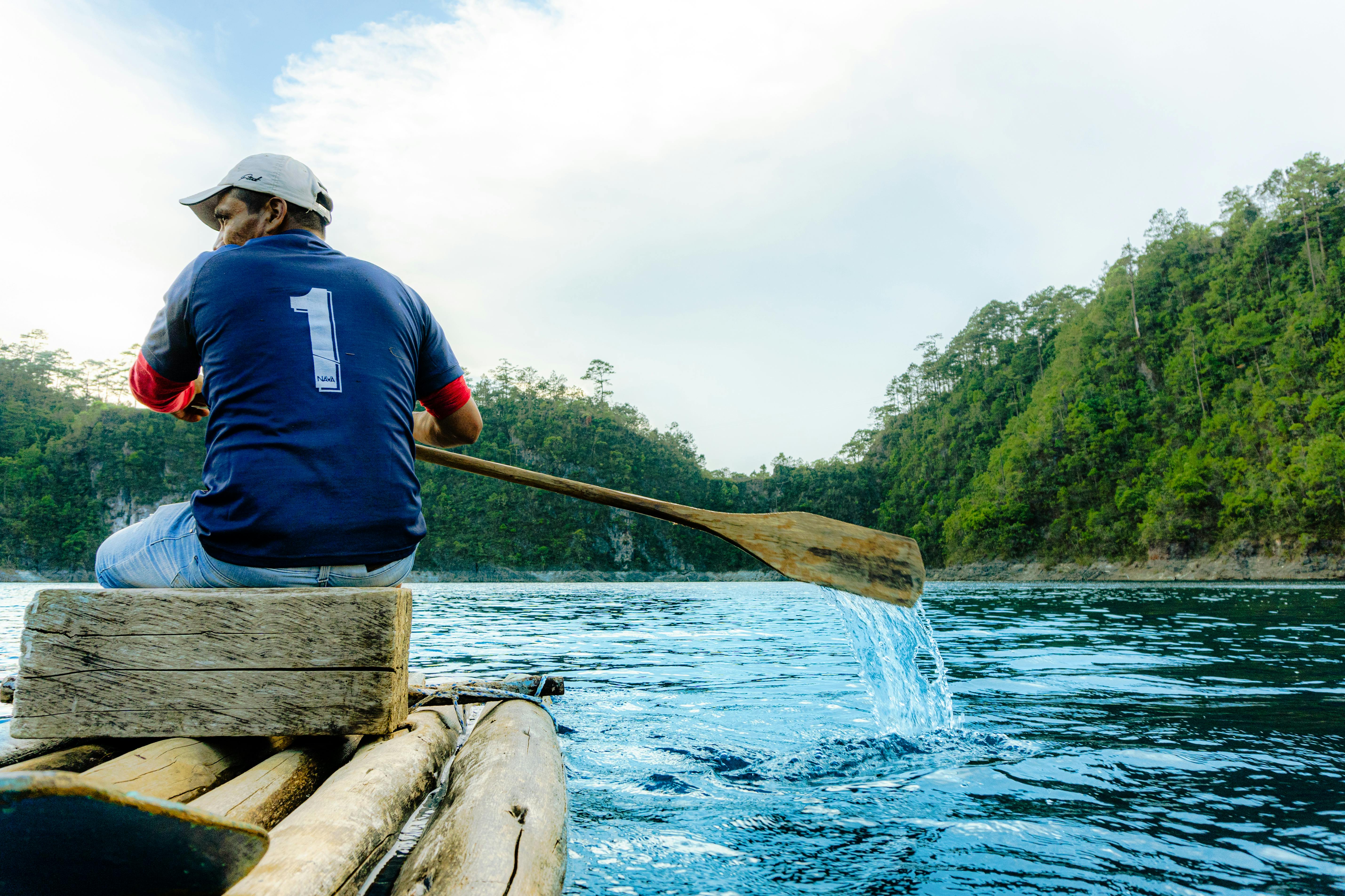 Man Rowing on Wooden Raft · Free Stock Photo