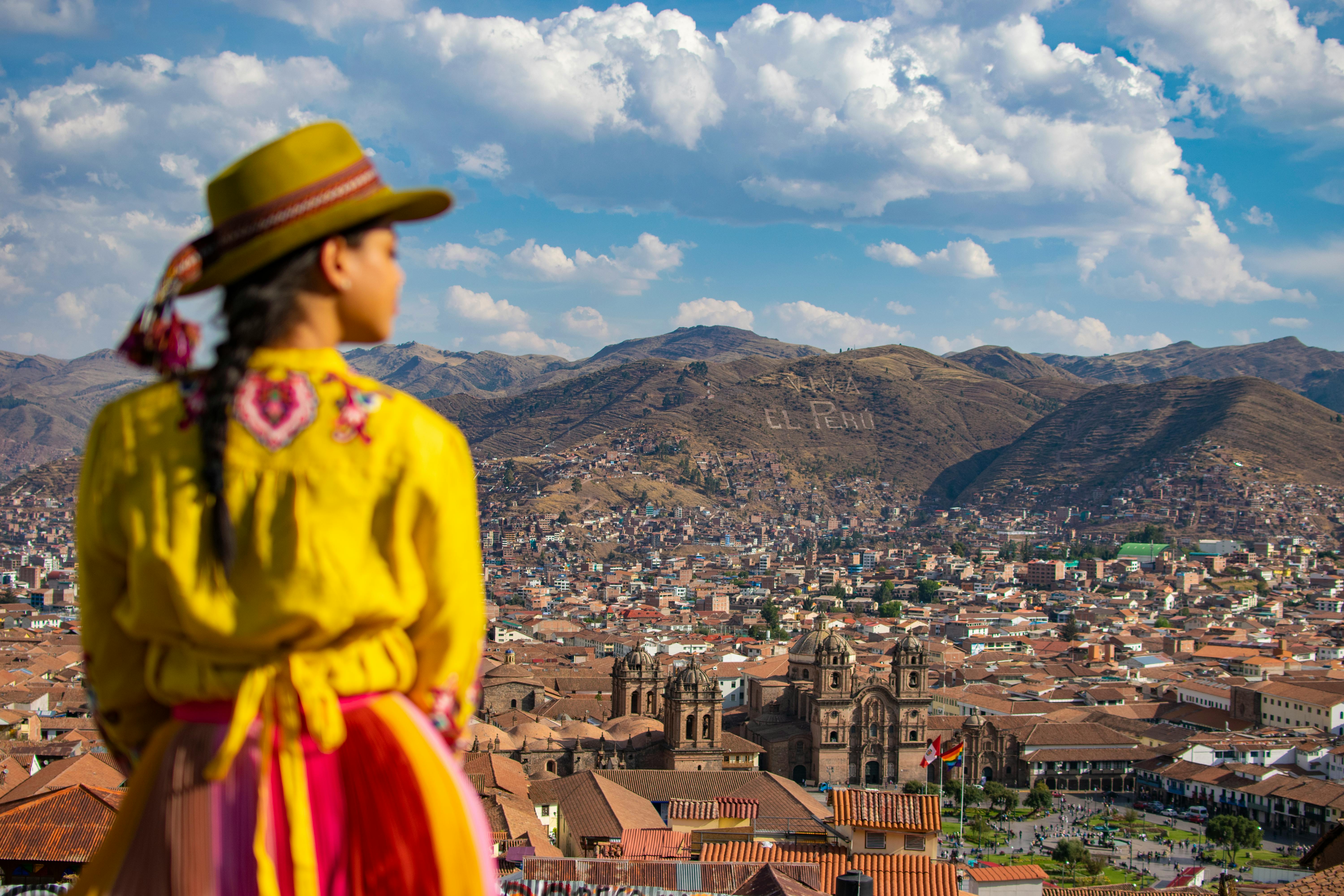 Cuzco Buildings behind Woman Sitting in Traditional Clothing · Free ...