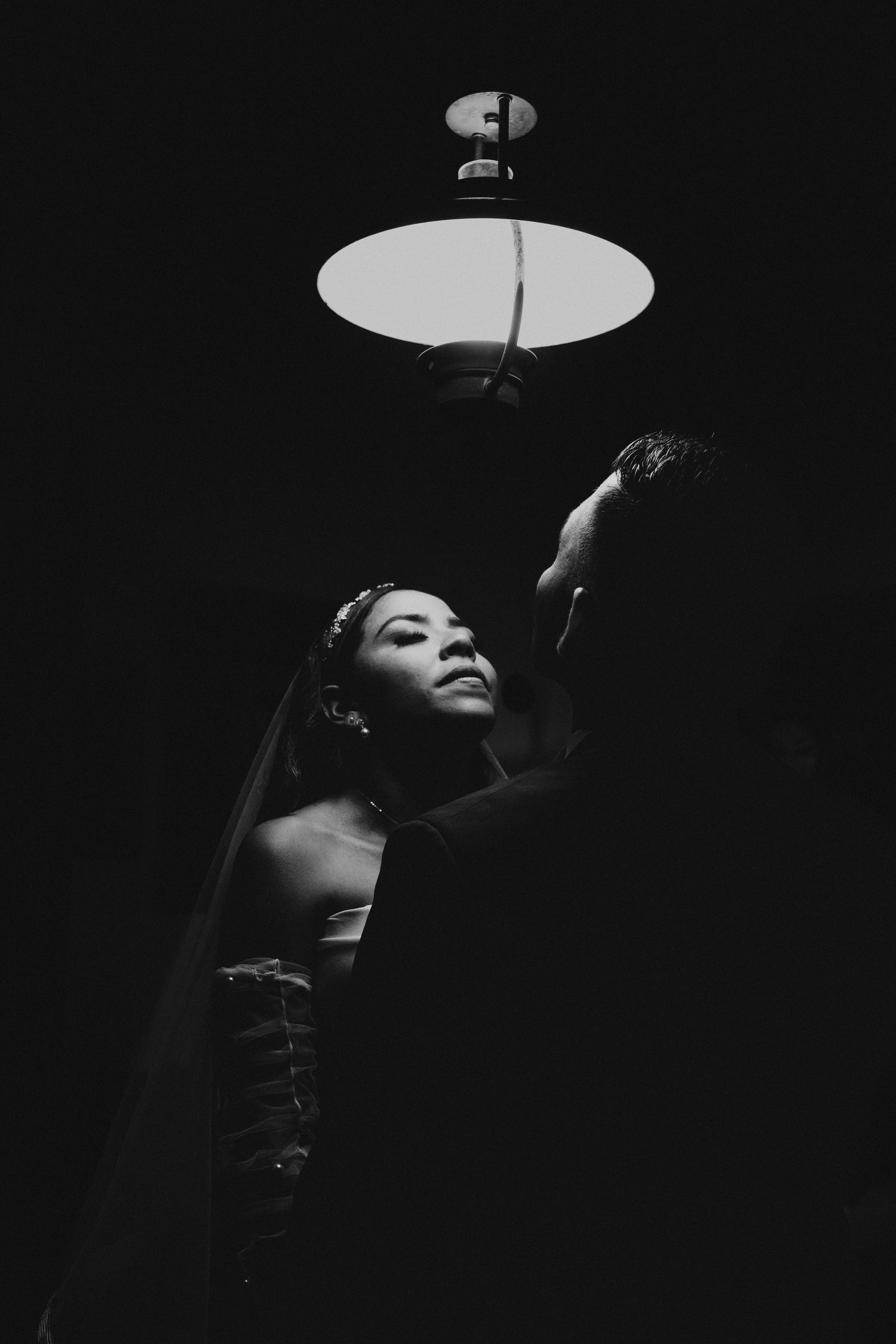 Woman Posing with Man under Lamp in Darkness · Free Stock Photo