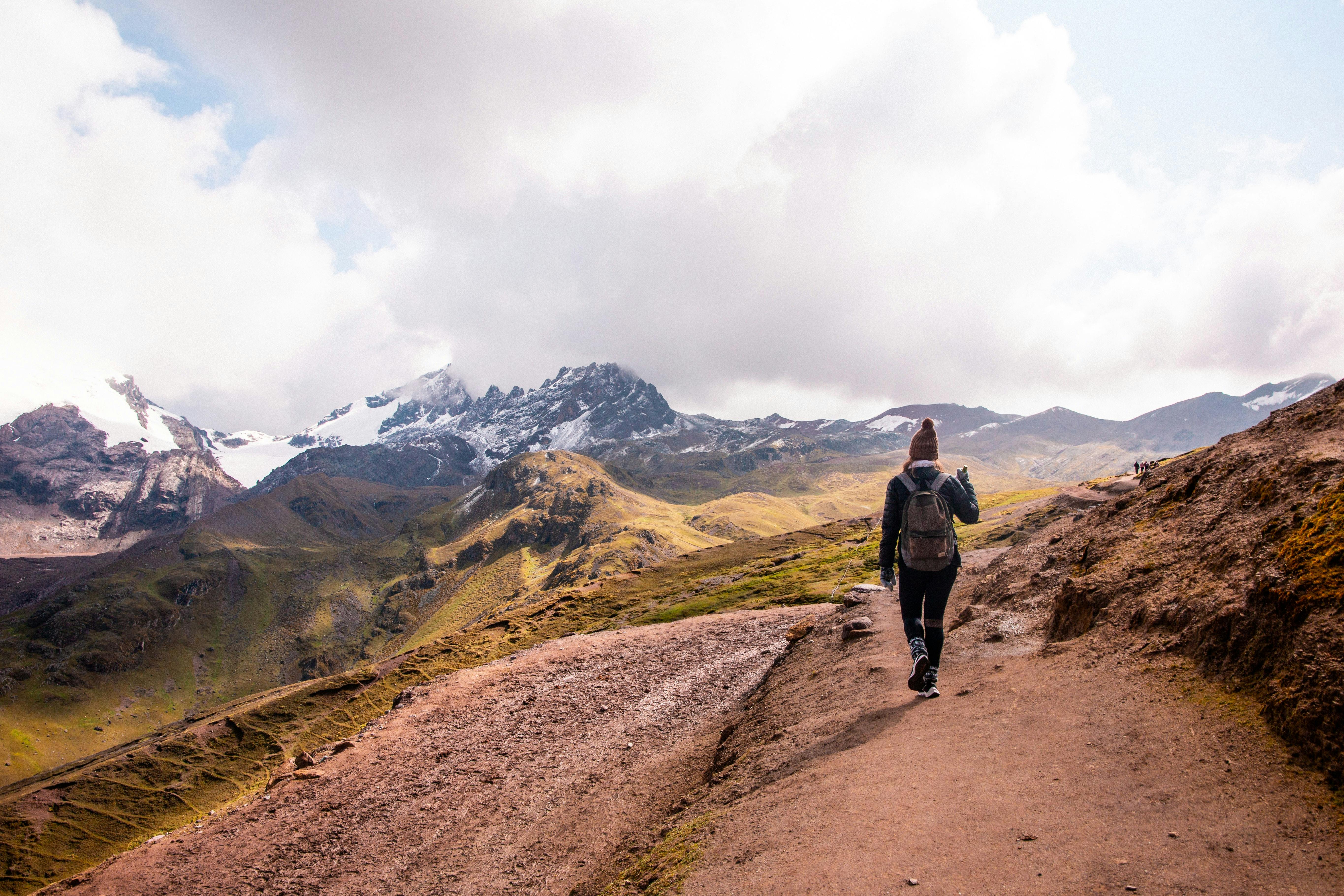 Woman Walking on Path Hiking in Mountains Landscape · Free Stock Photo