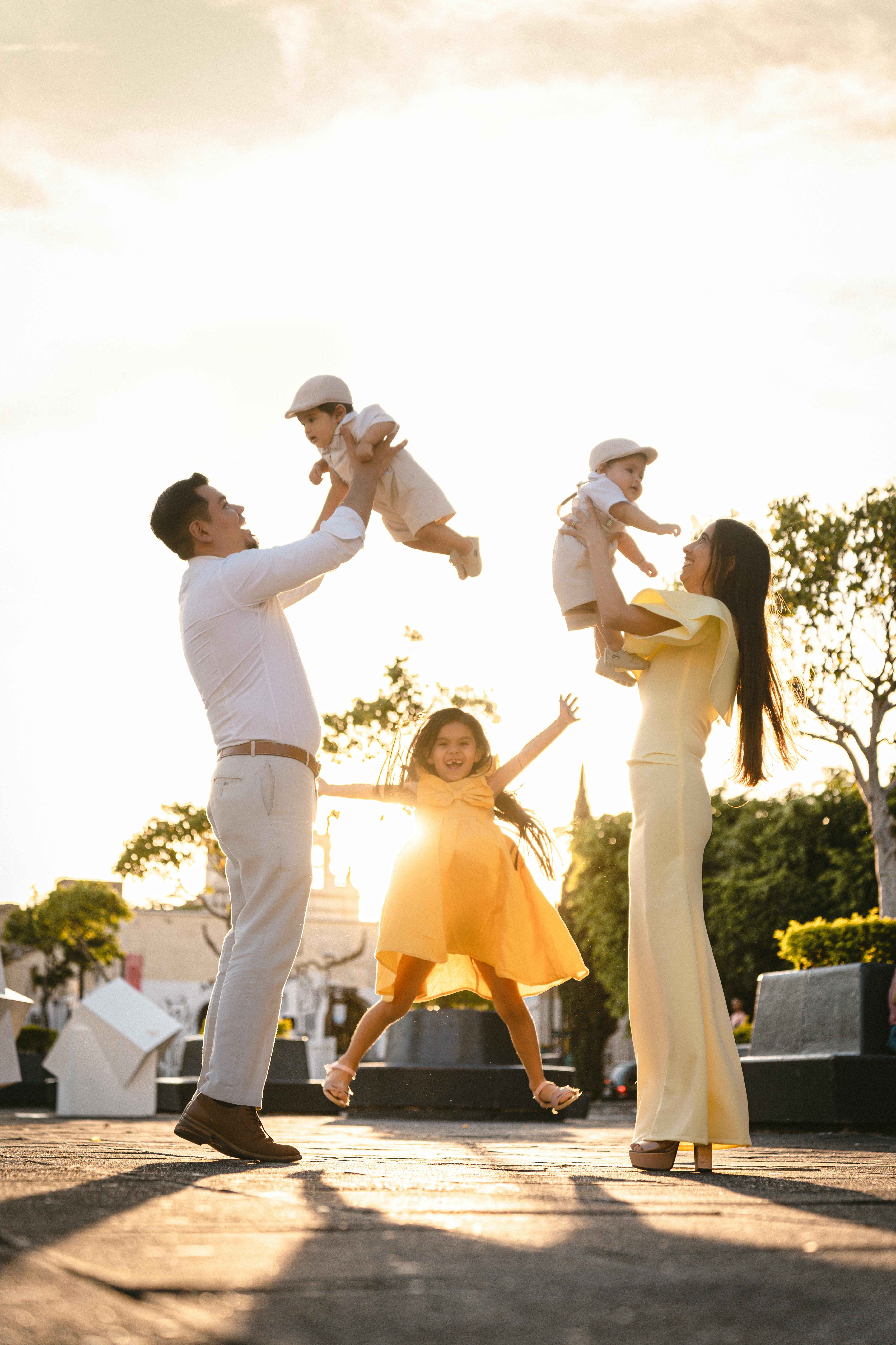 Mother and Father Raising Babies up with Daughter Jumping between ...
