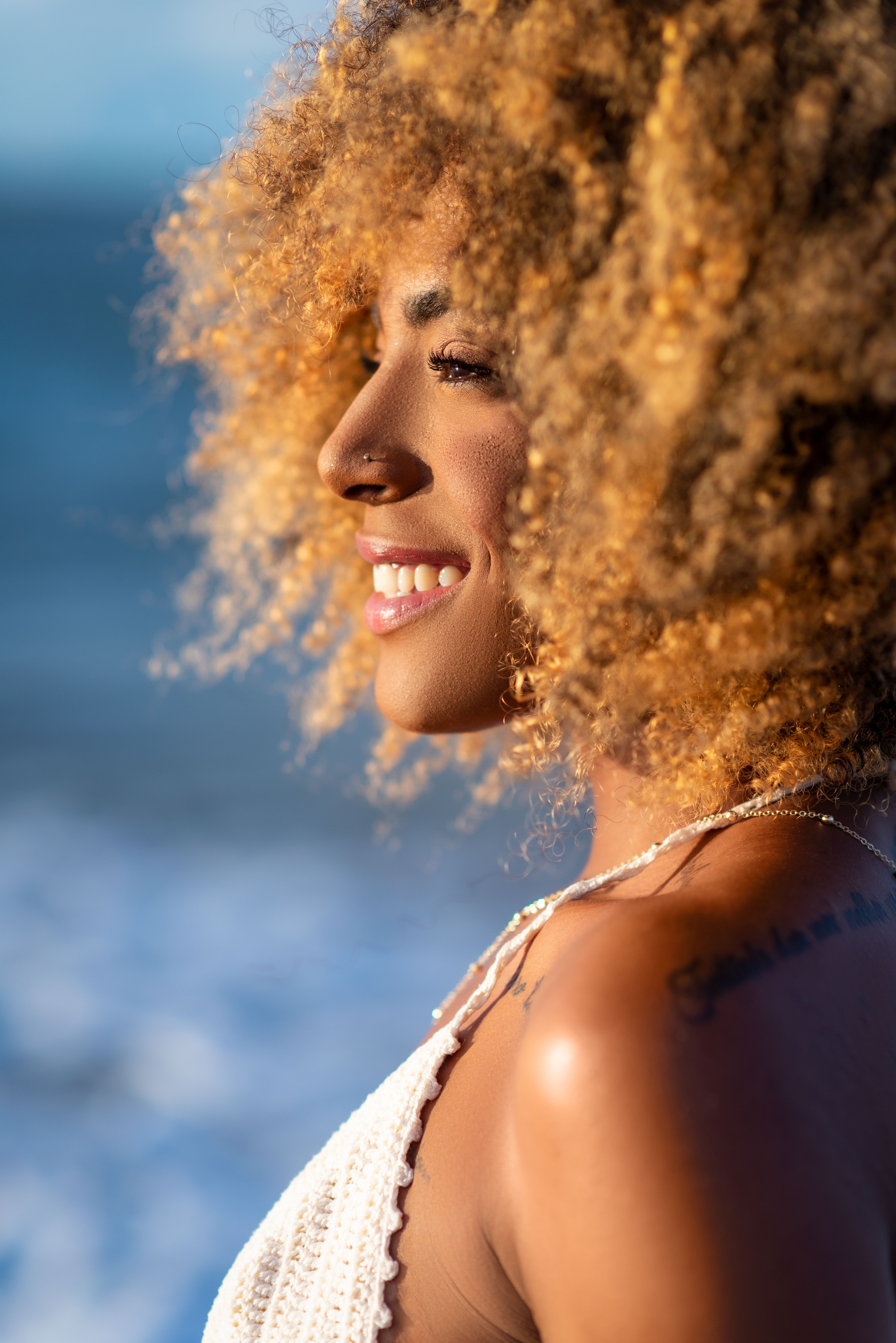 Profile of a Smiling Woman with Curly Hair · Free Stock Photo