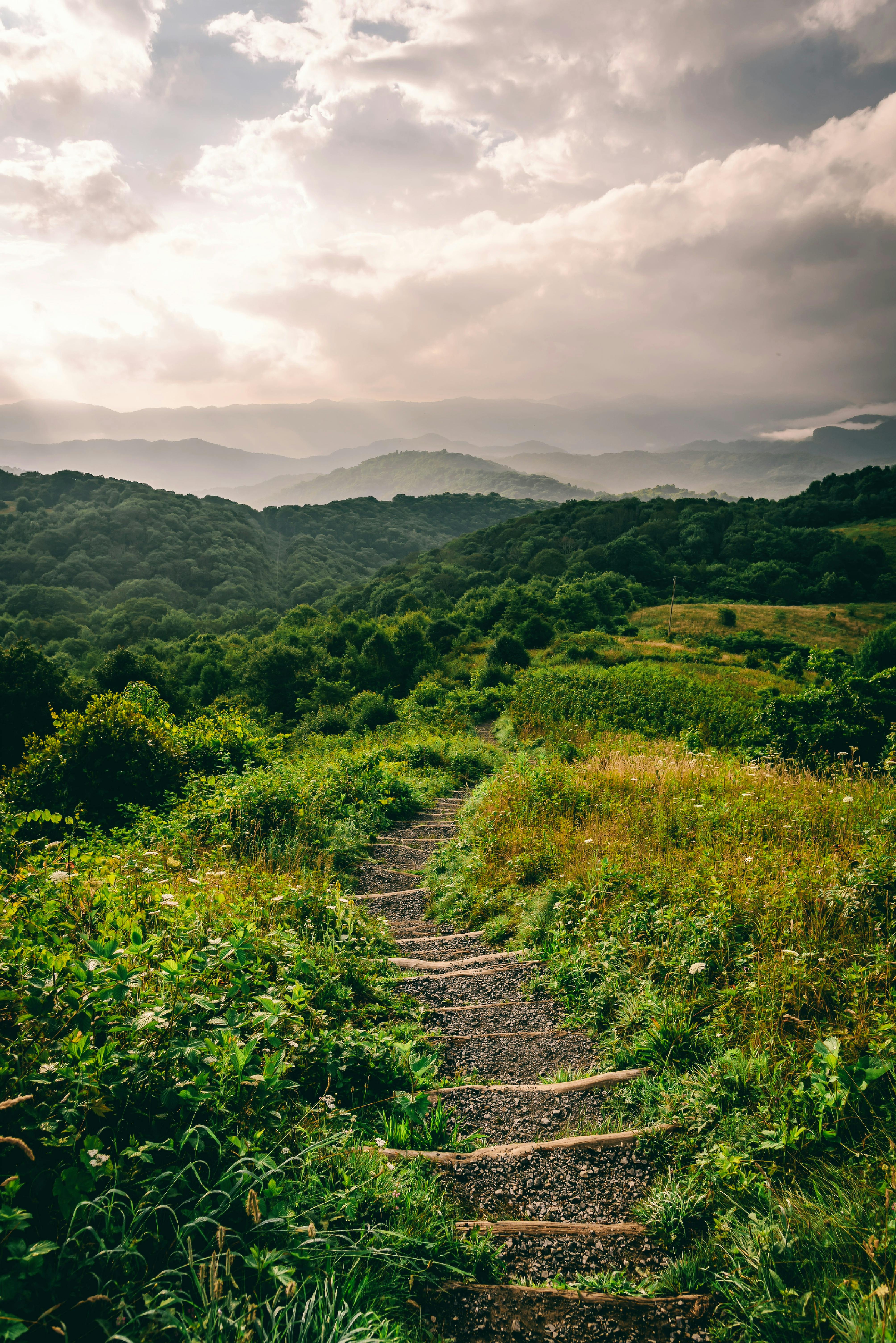 A path through the mountains with a cloudy sky · Free Stock Photo