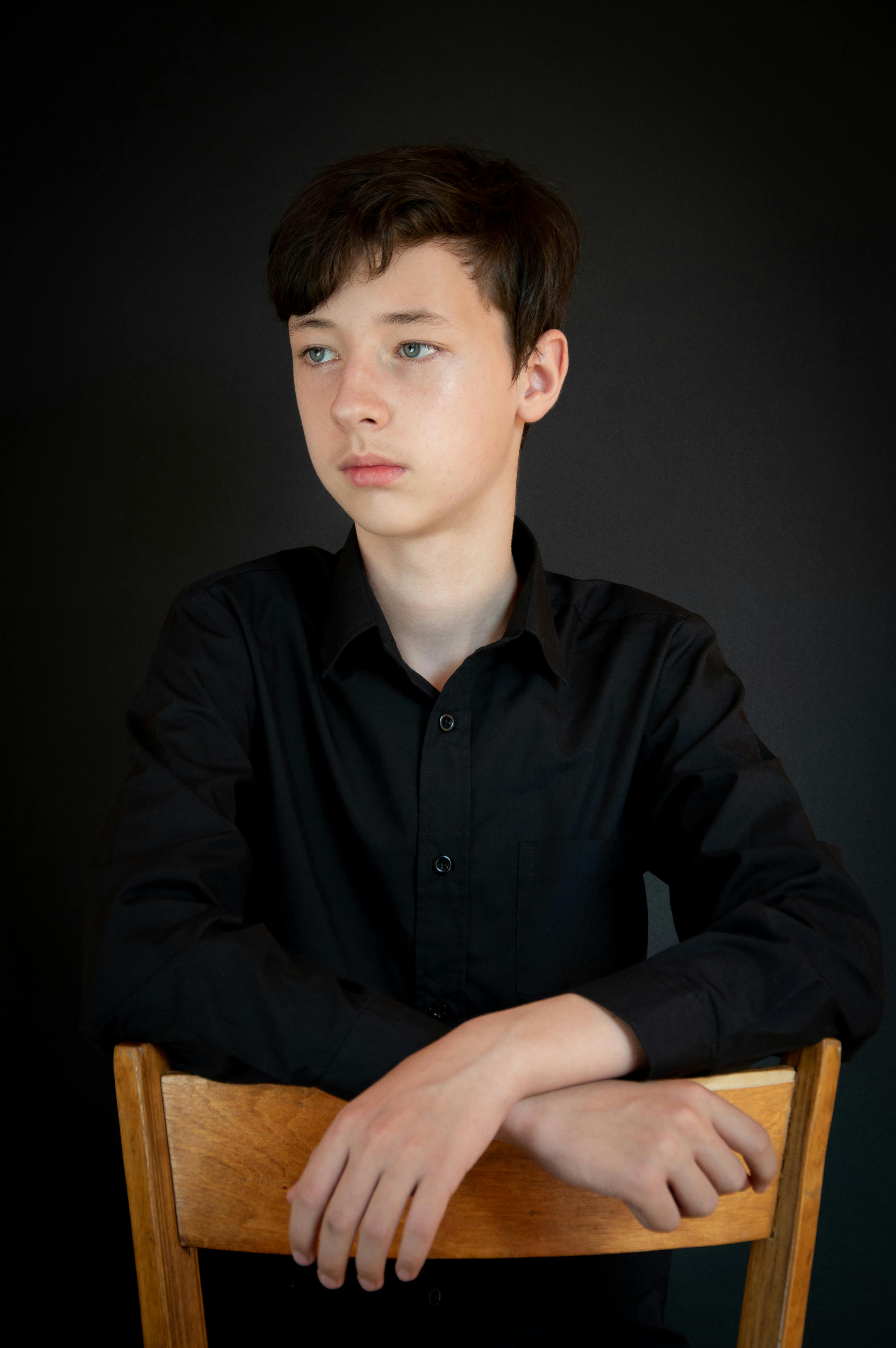 A Boy Looking from Behind of Backrest of a Black Chair · Free Stock Photo