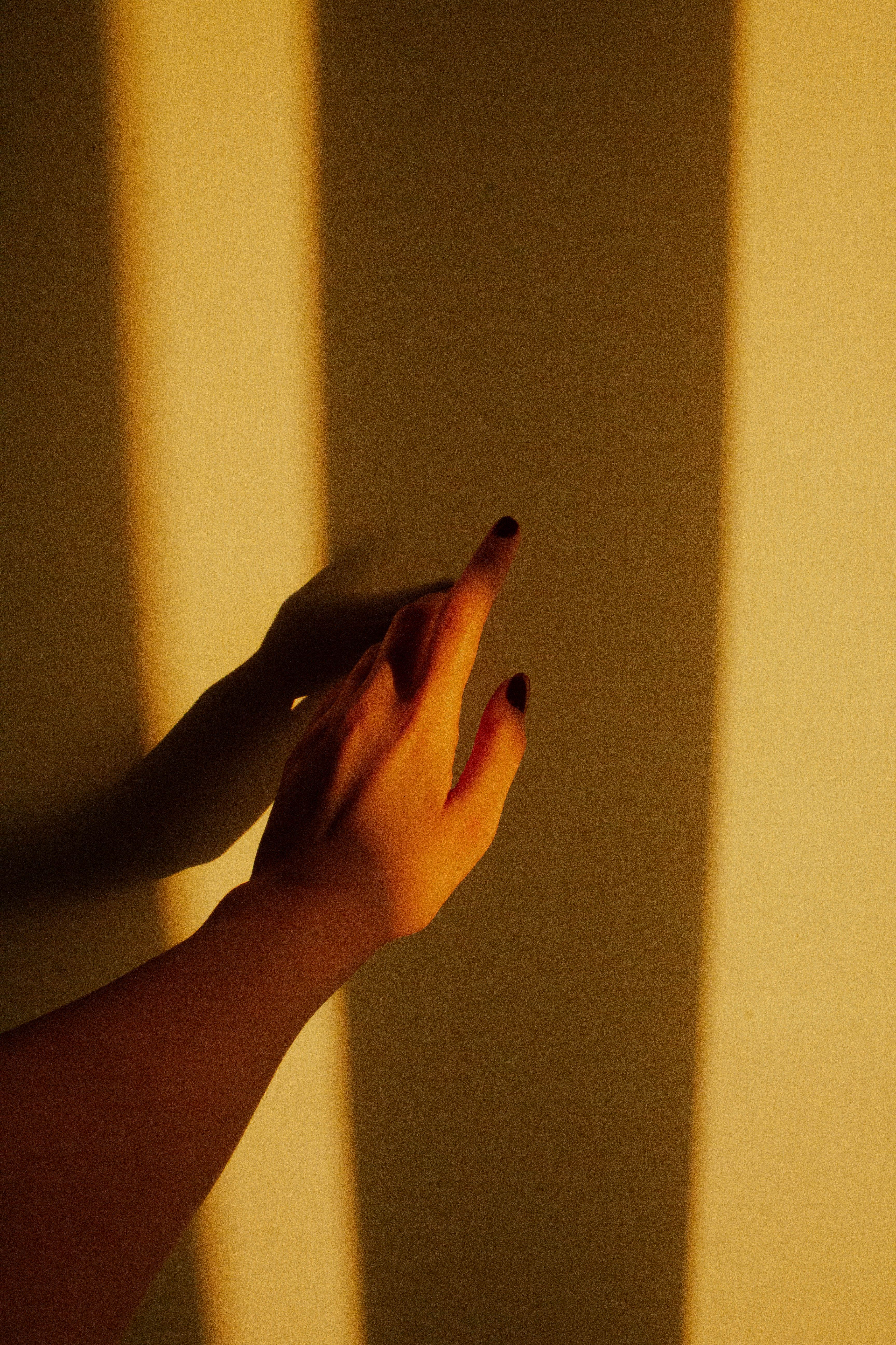 Gorgeous woman raising arms to electric lamp in dark room · Free Stock ...