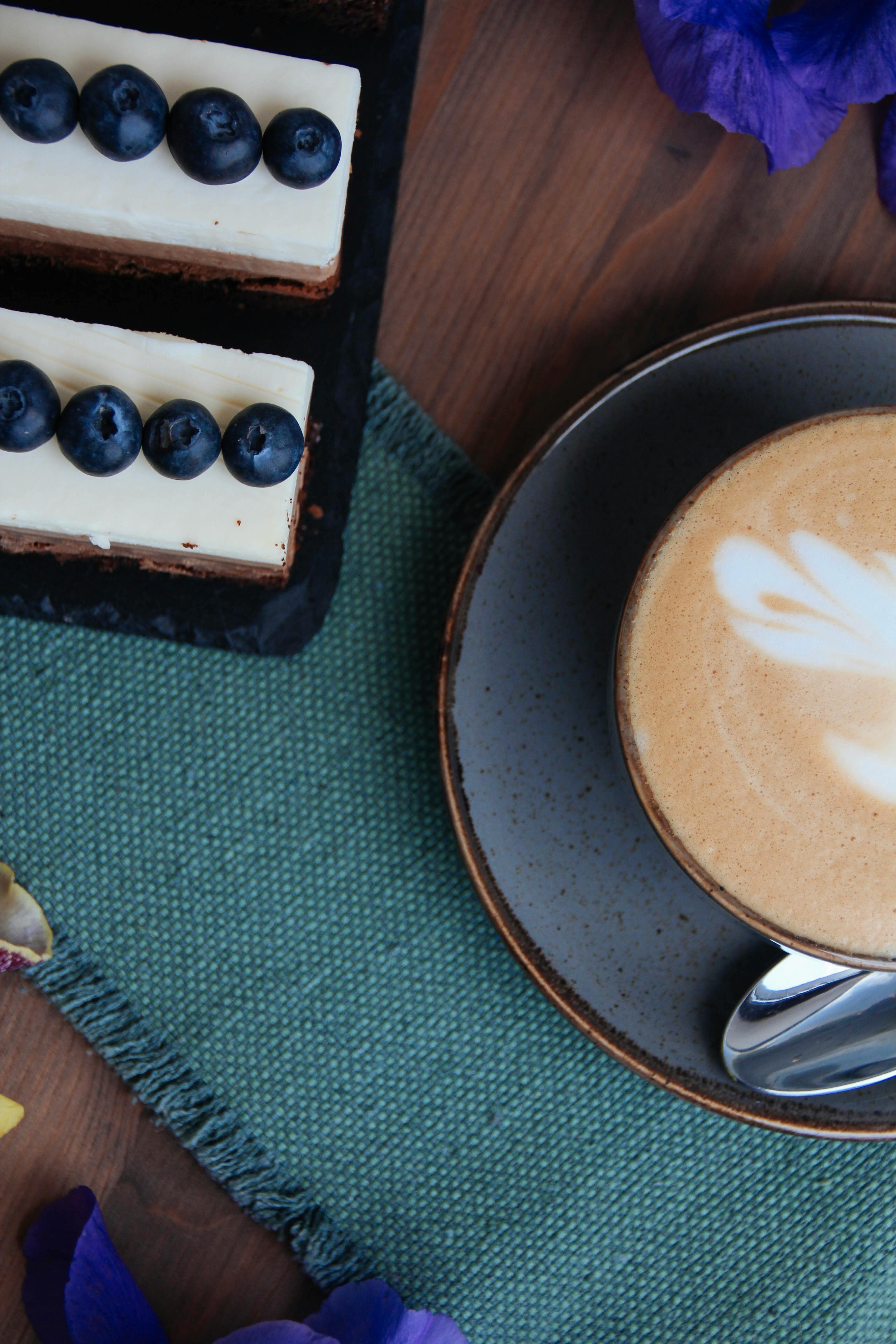 Top View of a Cup of Coffee and a Cake with Blueberries · Free Stock Photo