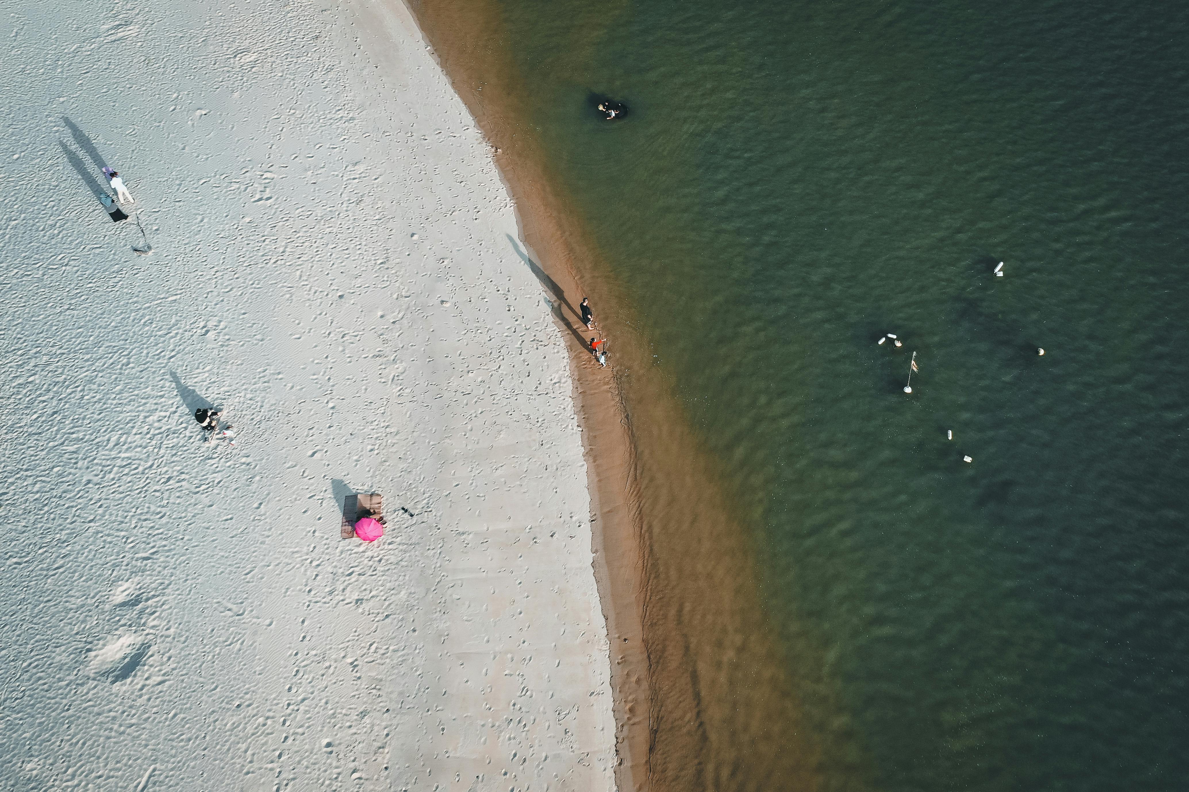 Aerial Footage of People on a Sandy Shore · Free Stock Photo