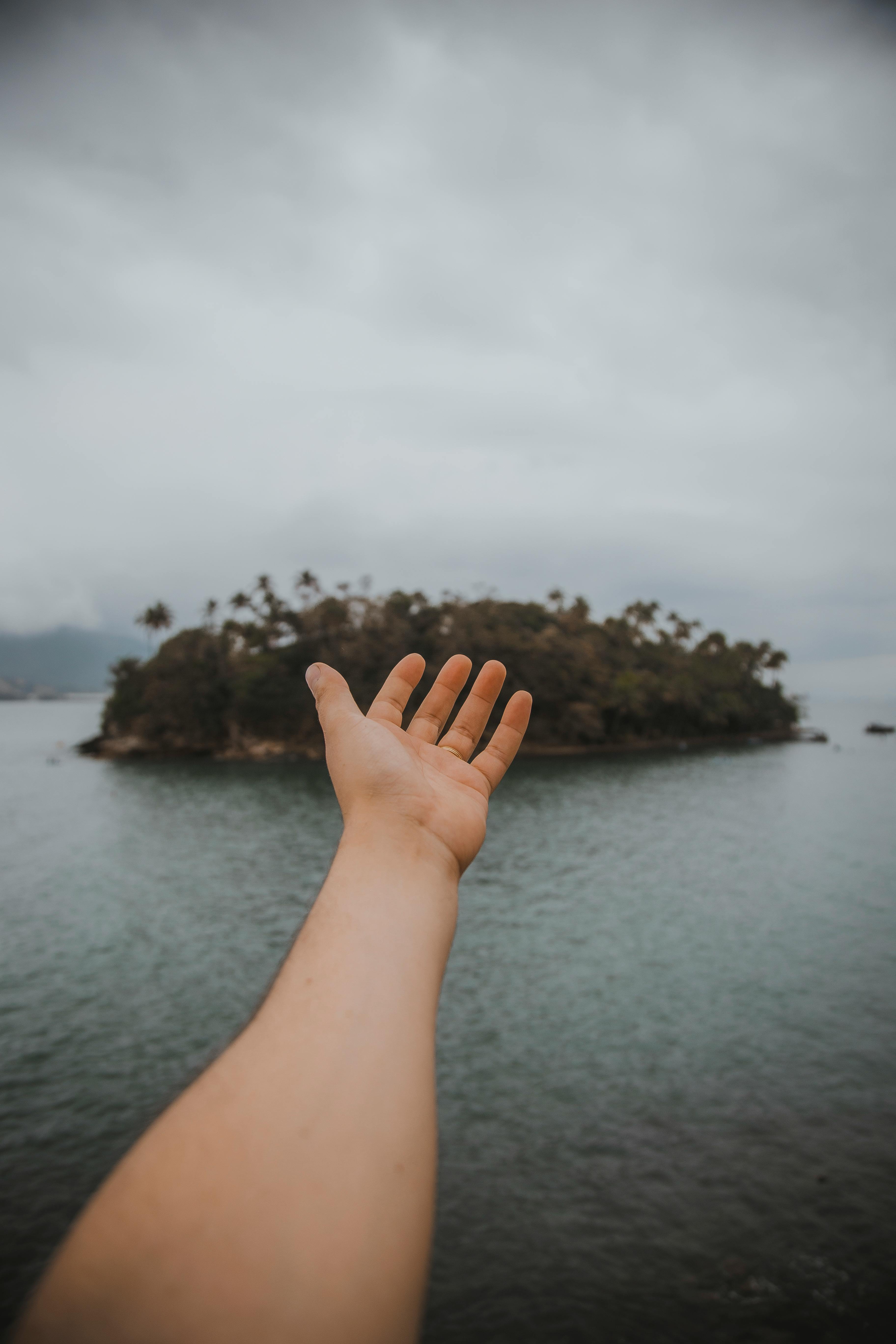 Hand Reaching Towards an Islet in the Sea · Free Stock Photo