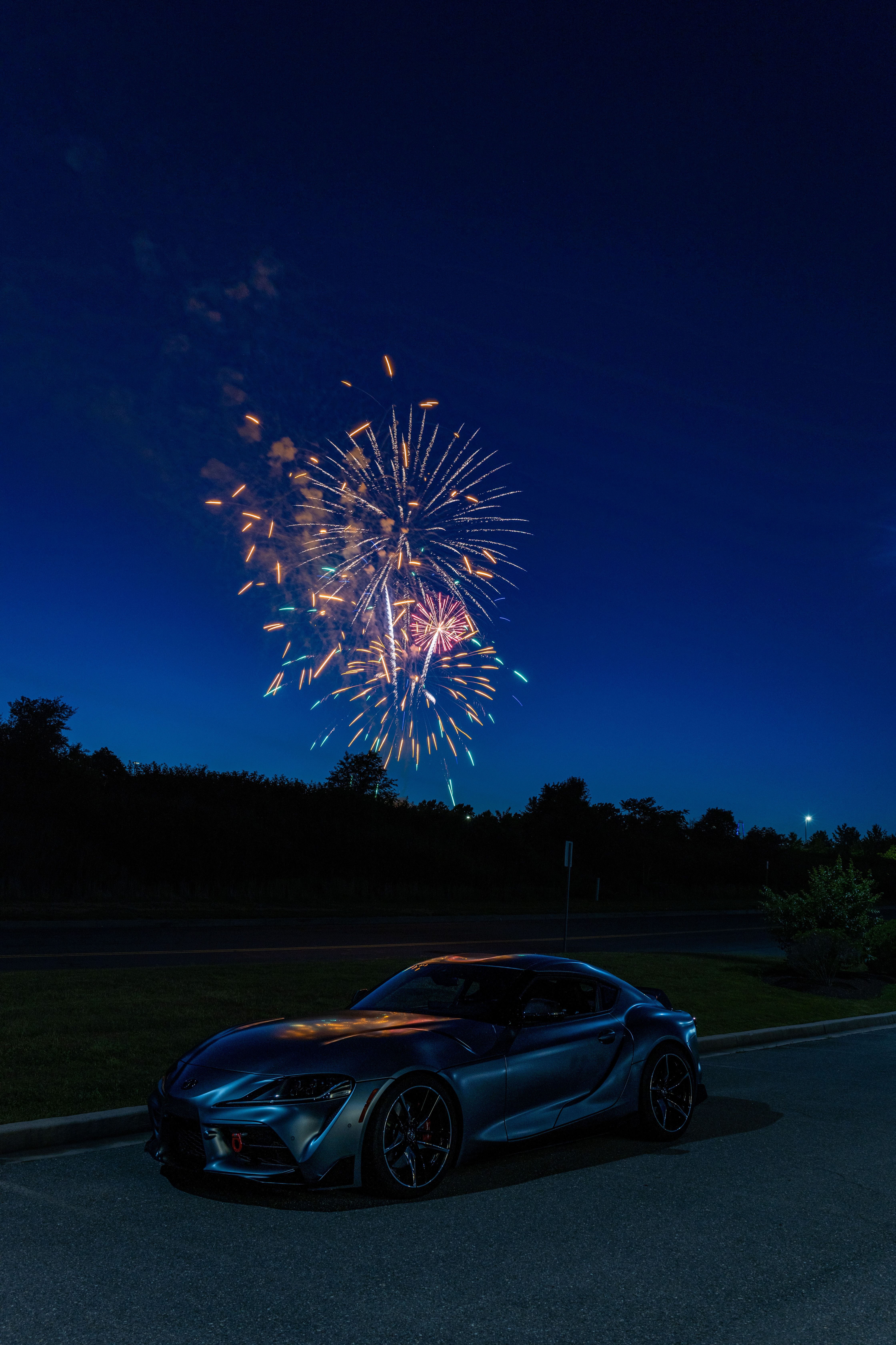 Fireworks over a sports car in the night sky · Free Stock Photo