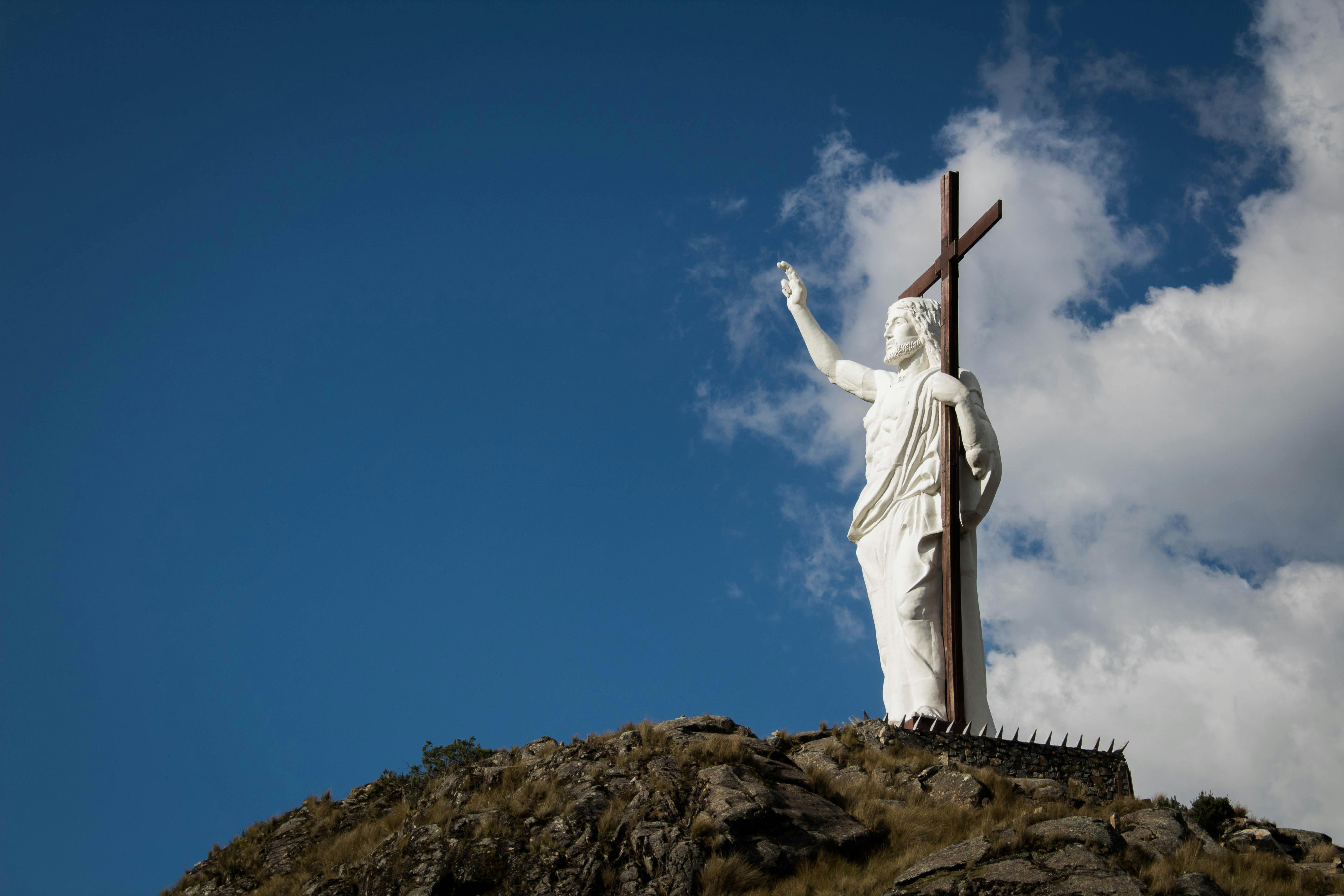 Statue of Jesus with Holy Cross in Hand on Hill · Free Stock Photo