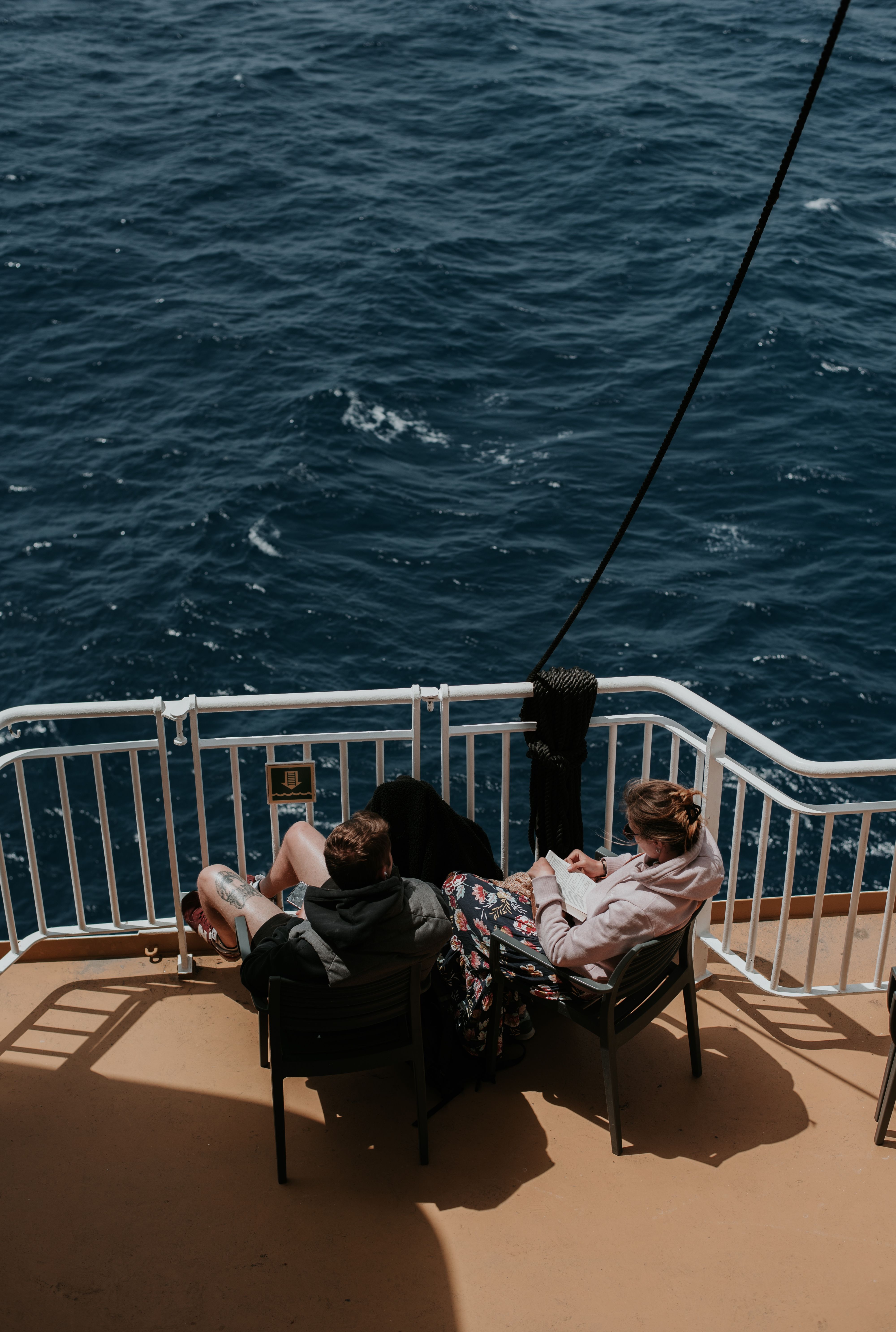 High Angle Shot of a Man and Woman Sitting on Chairs on a Ship · Free ...