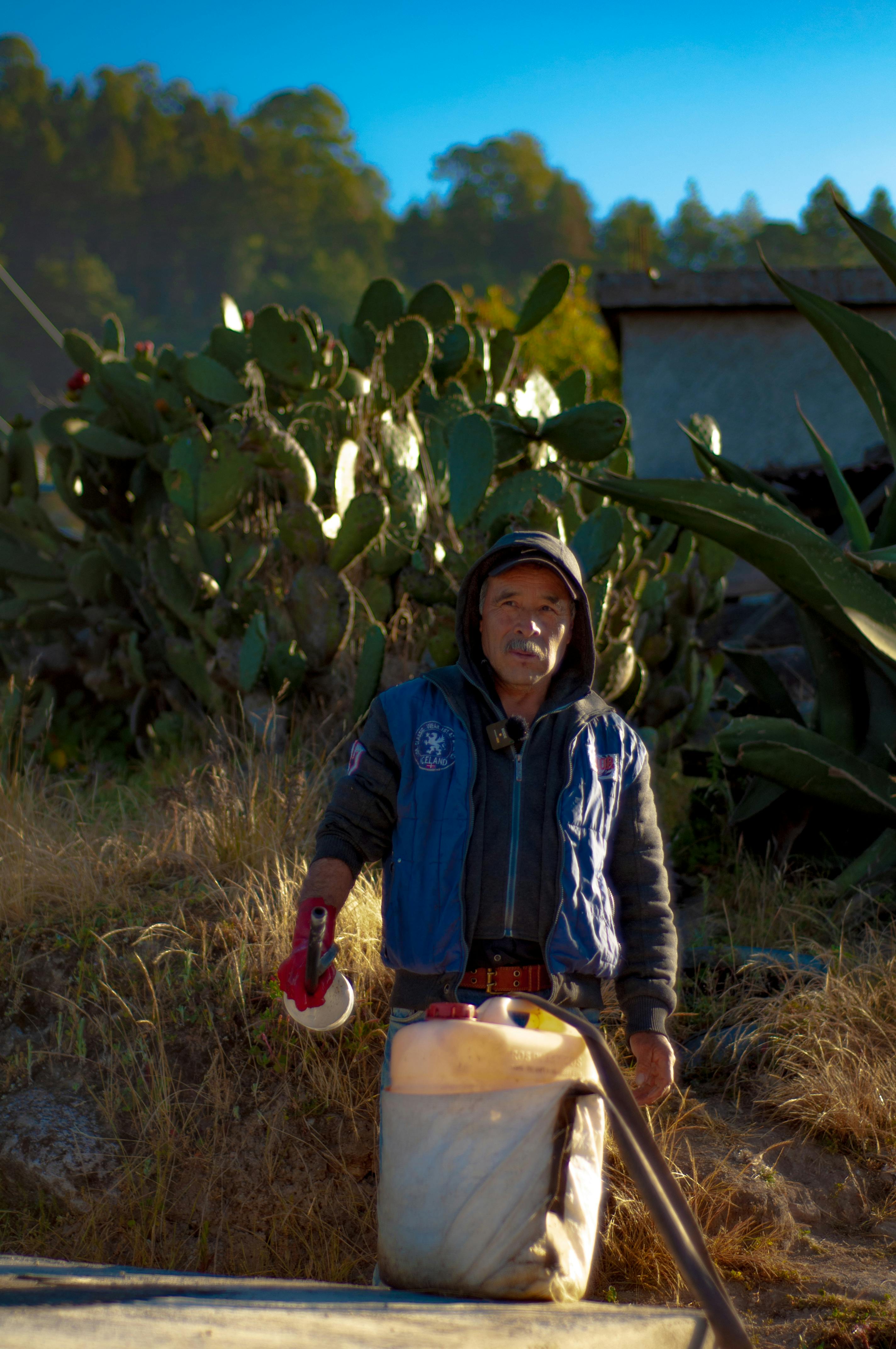 Elderly Man Carrying a Container on a Strap · Free Stock Photo