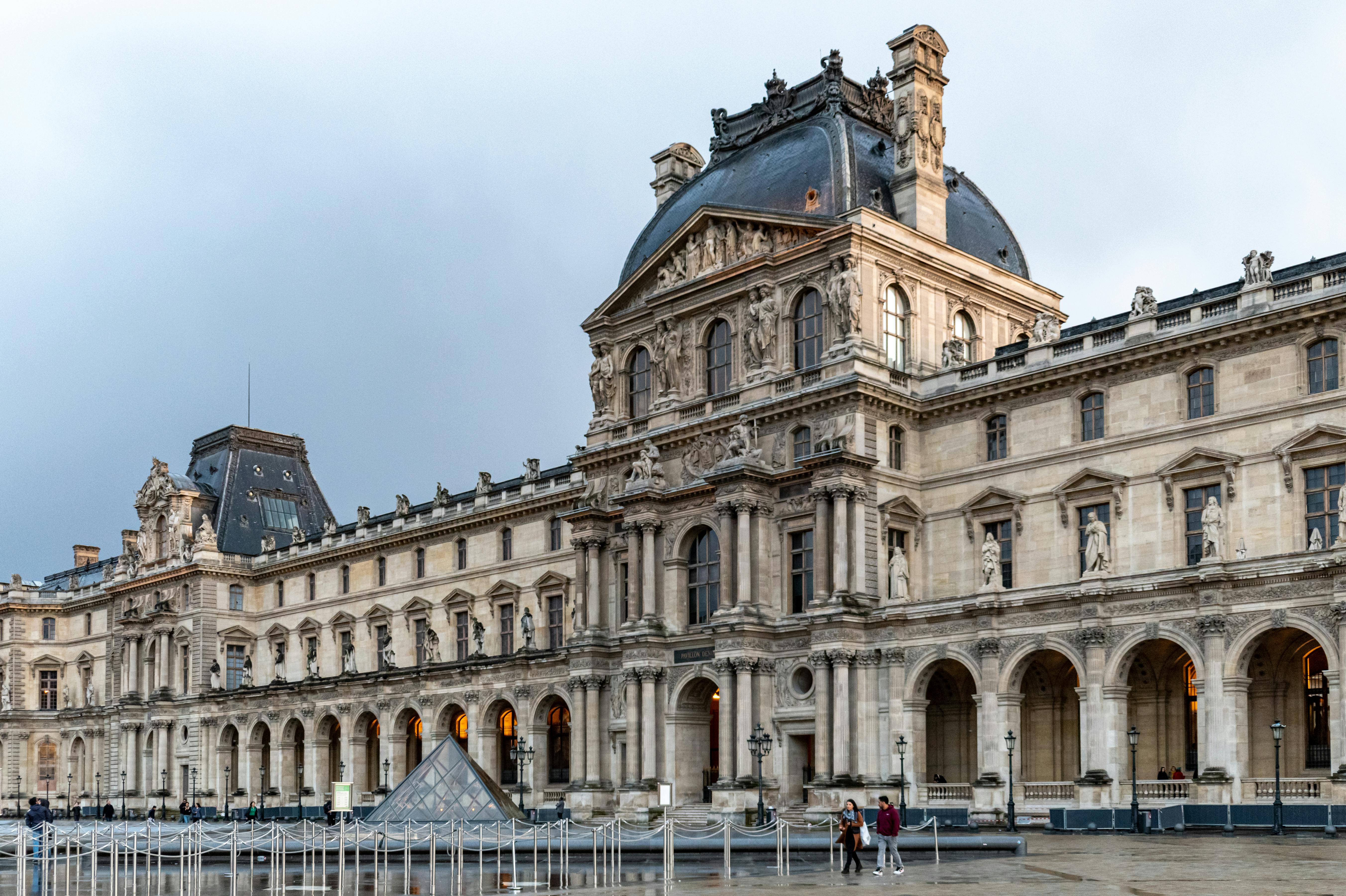 Louvre Museum Facade with French Flag on Rooftop · Free Stock Photo