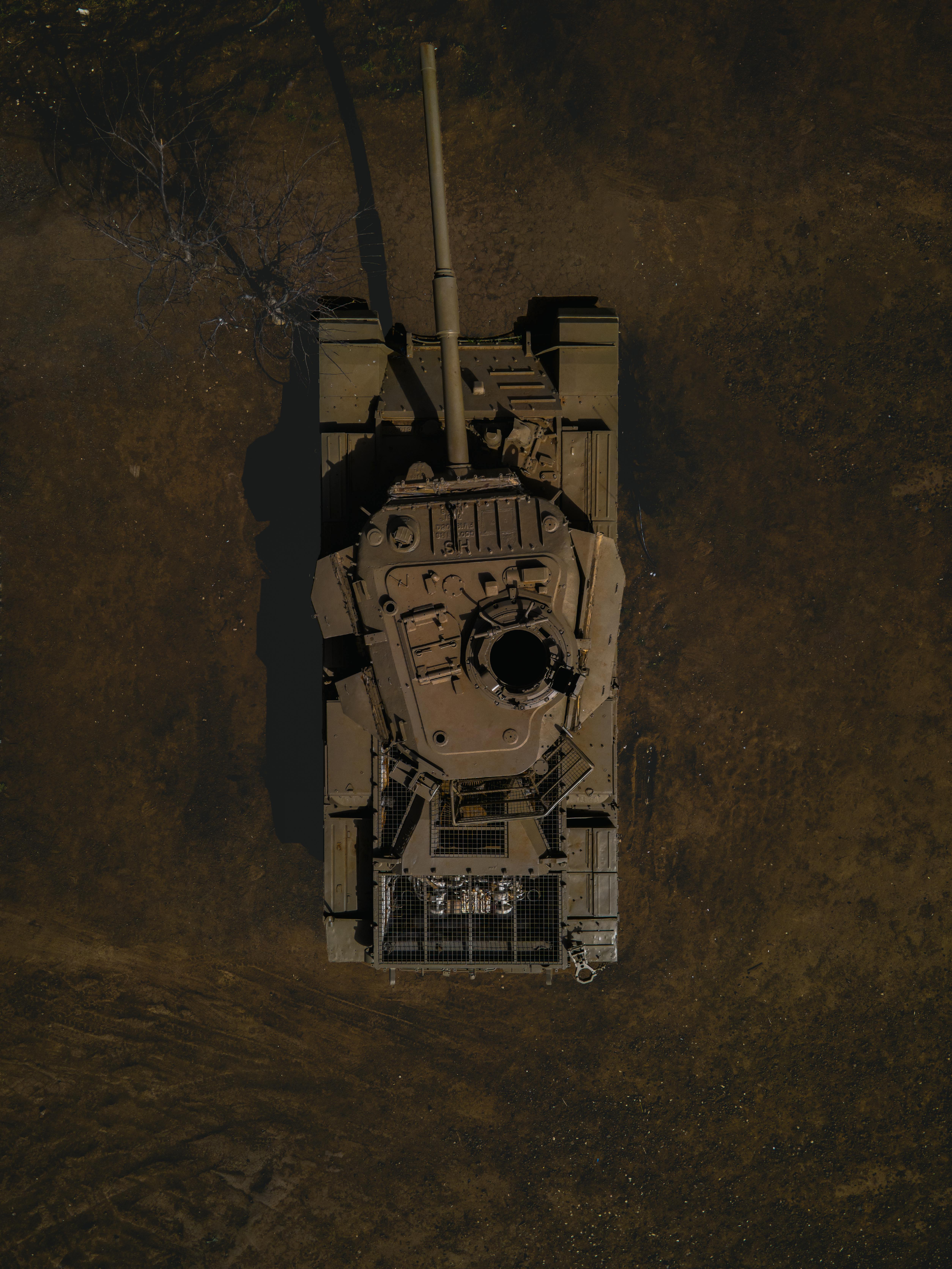 Dark Aerial Footage of a Tank on a Field · Free Stock Photo