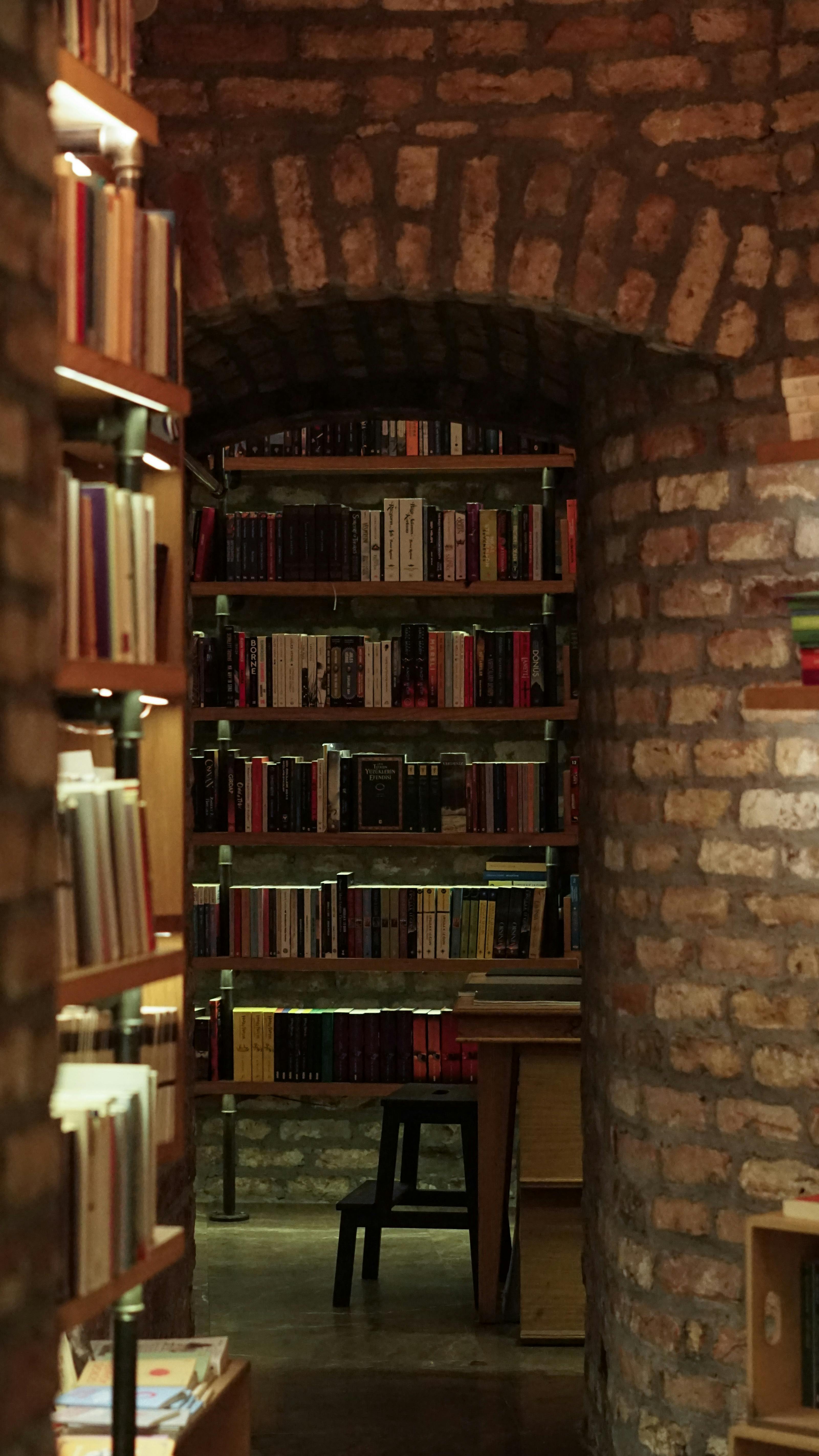A book shelf in a brick walled room · Free Stock Photo
