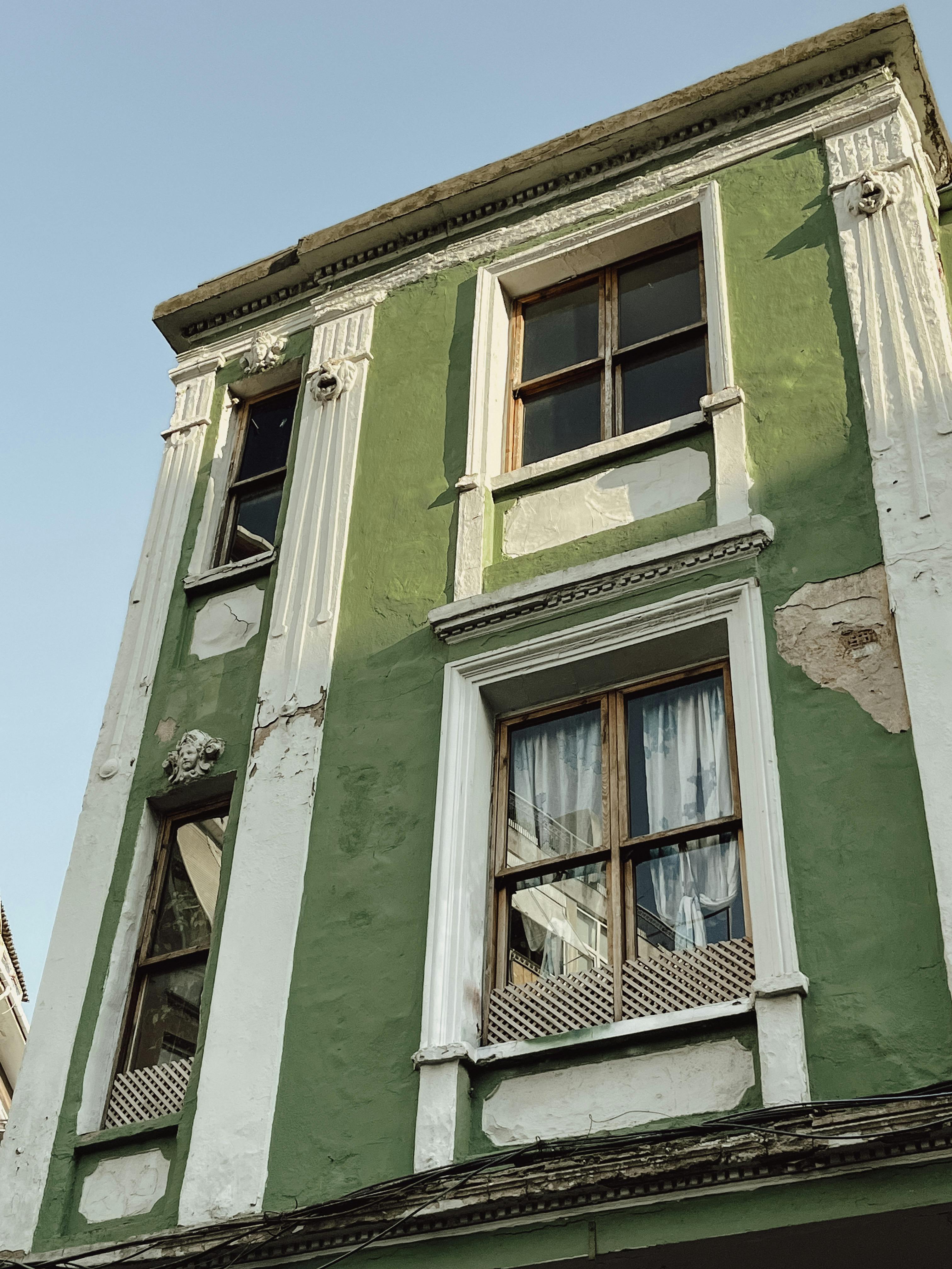 Dilapidated Facade of a Neoclassical Tenement House · Free Stock Photo