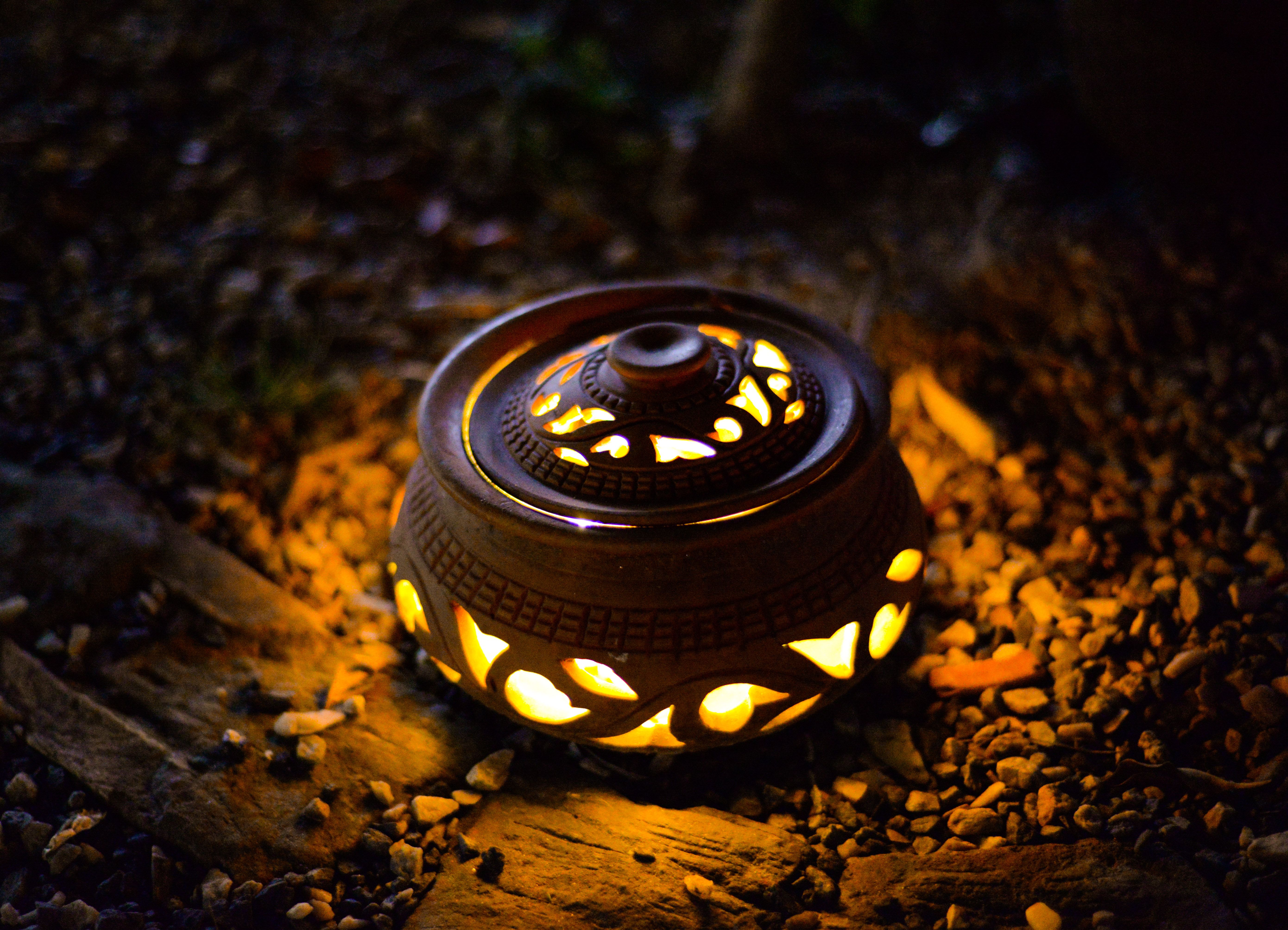 A small candle lit on the ground · Free Stock Photo