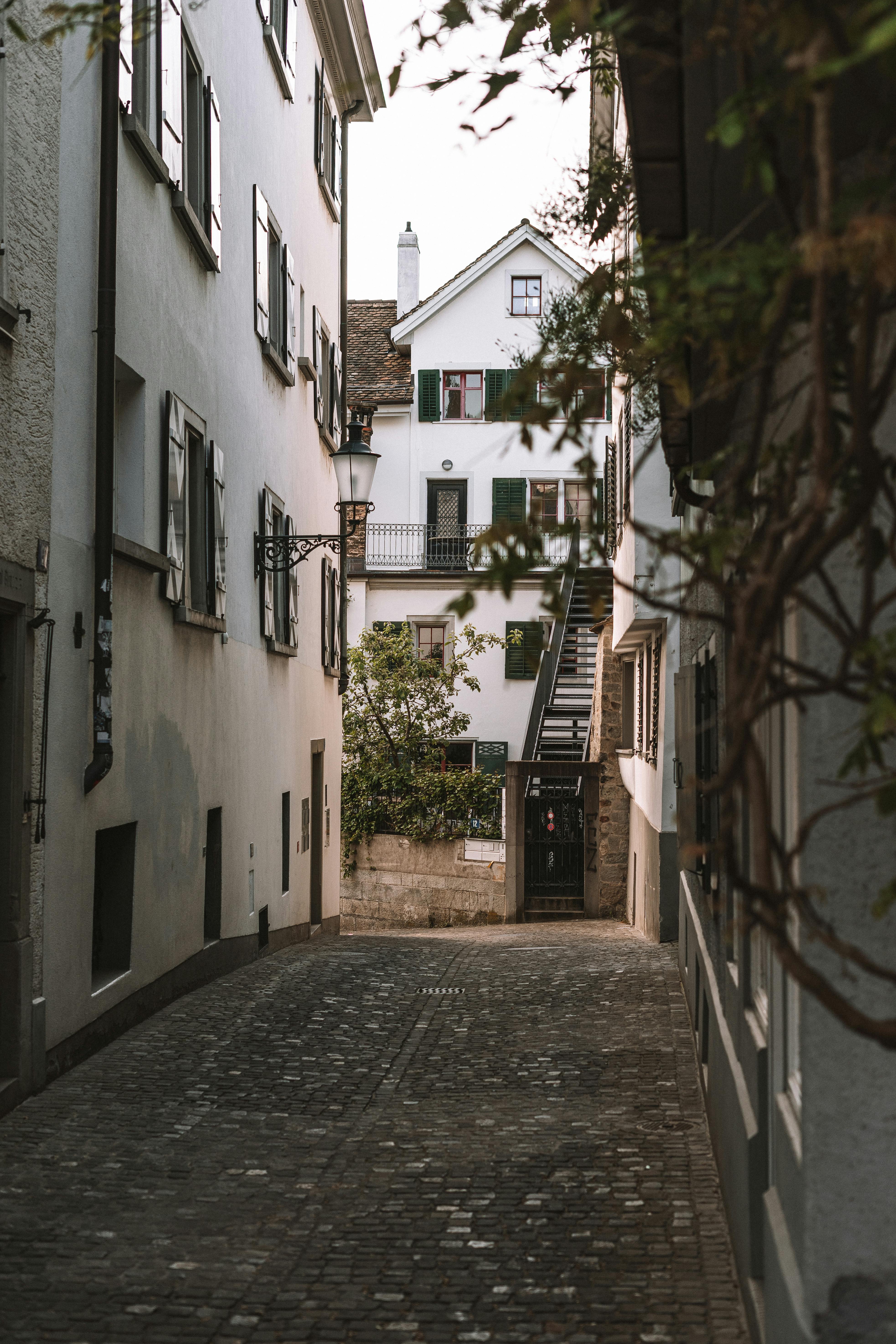 Concrete Road Between Wall And Houses · Free Stock Photo