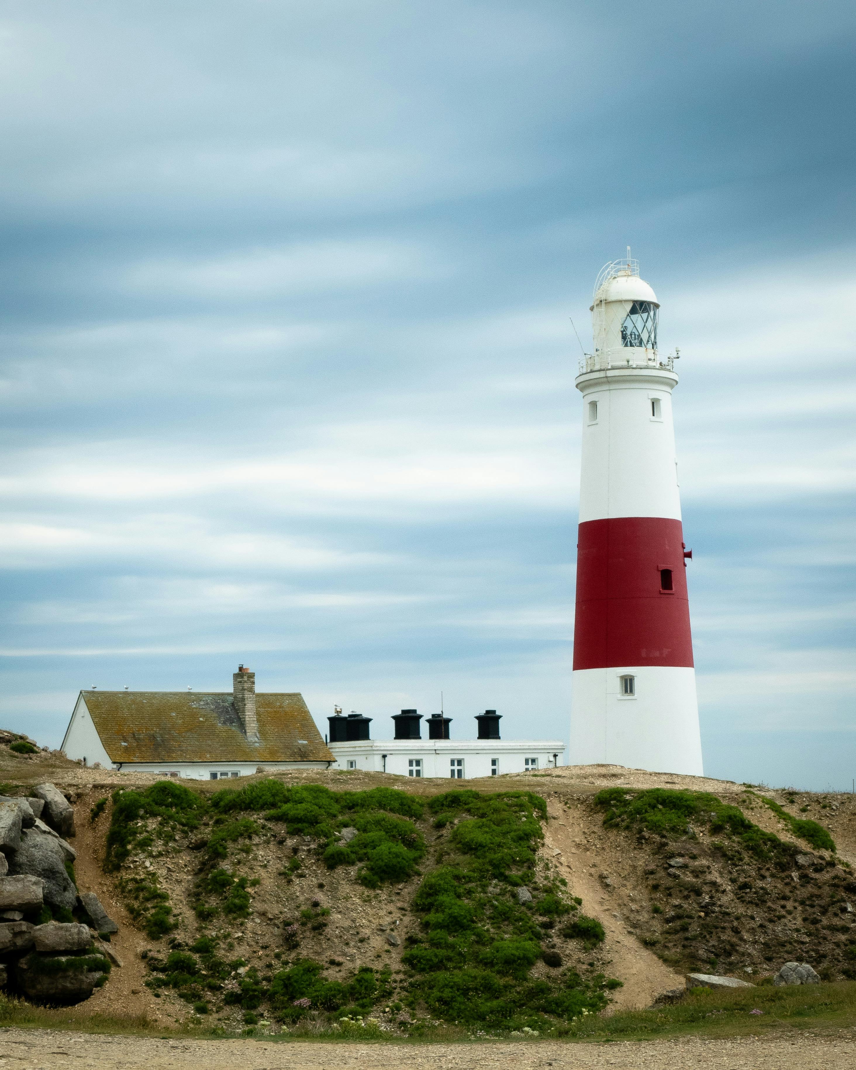 White and Black Lighthouse Near Gray Body of Water · Free Stock Photo