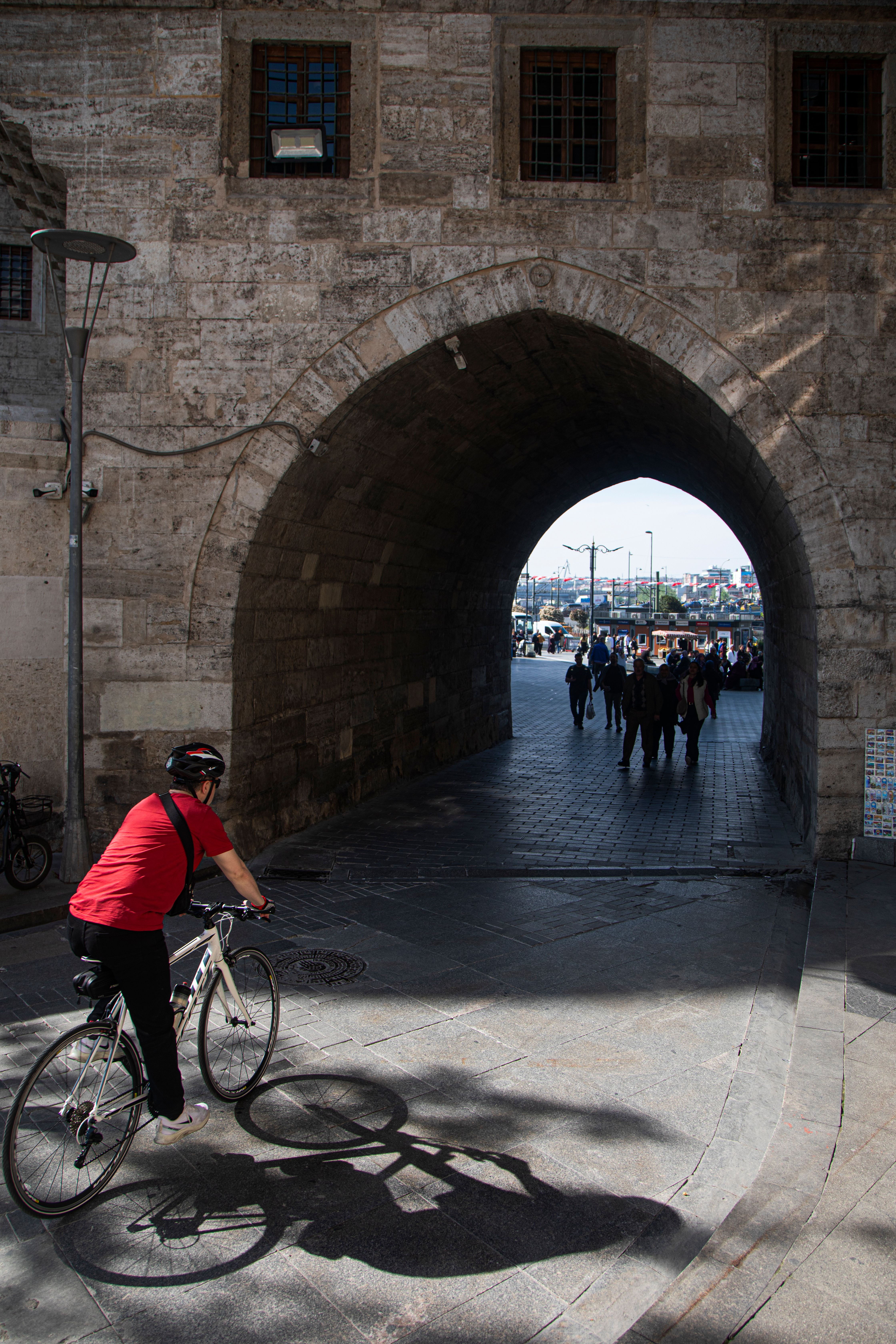 Tourists Under the Archway Through the Stone Building · Free Stock Photo