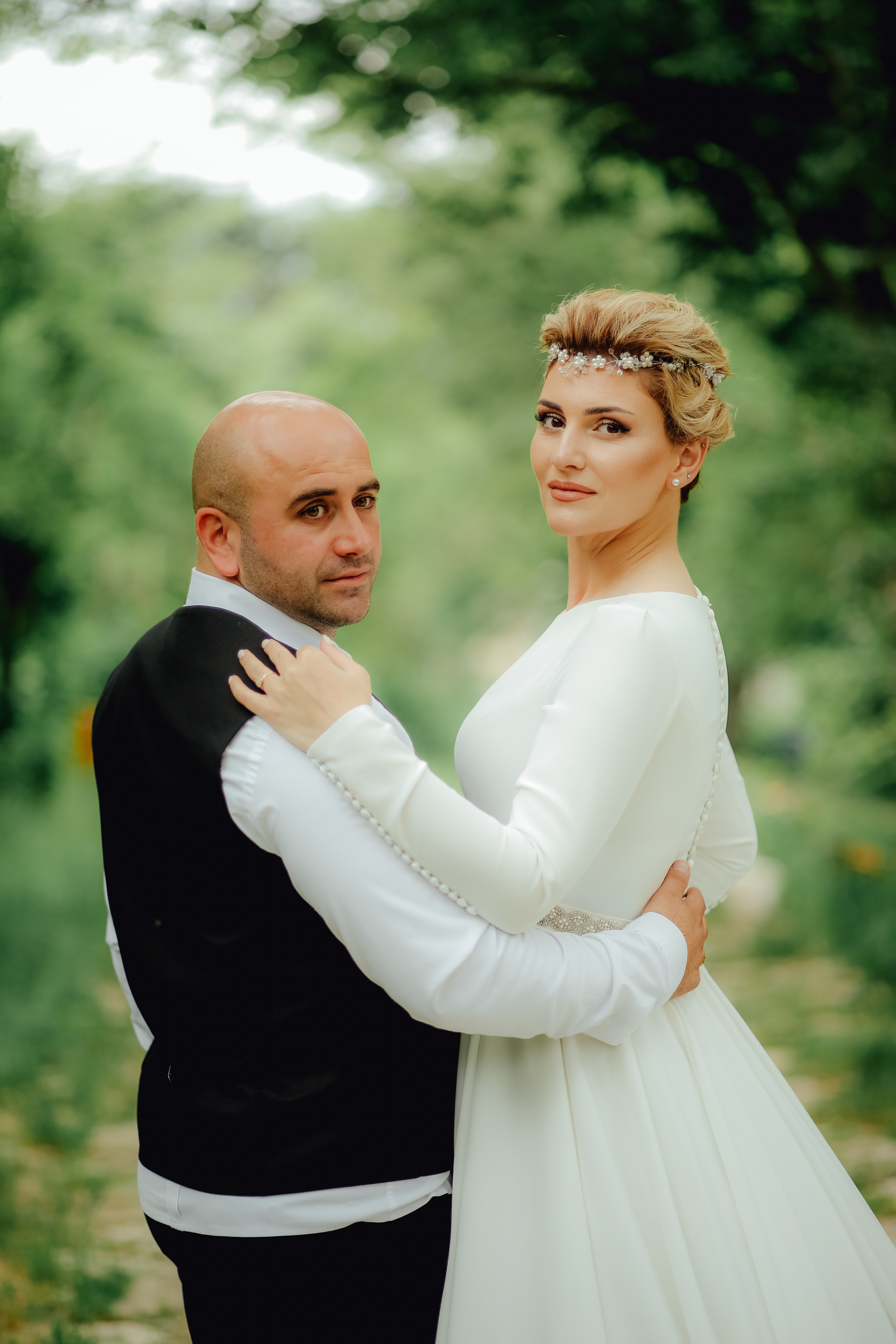 Embracing Bride and Groom Looking over their Shoulders · Free Stock Photo