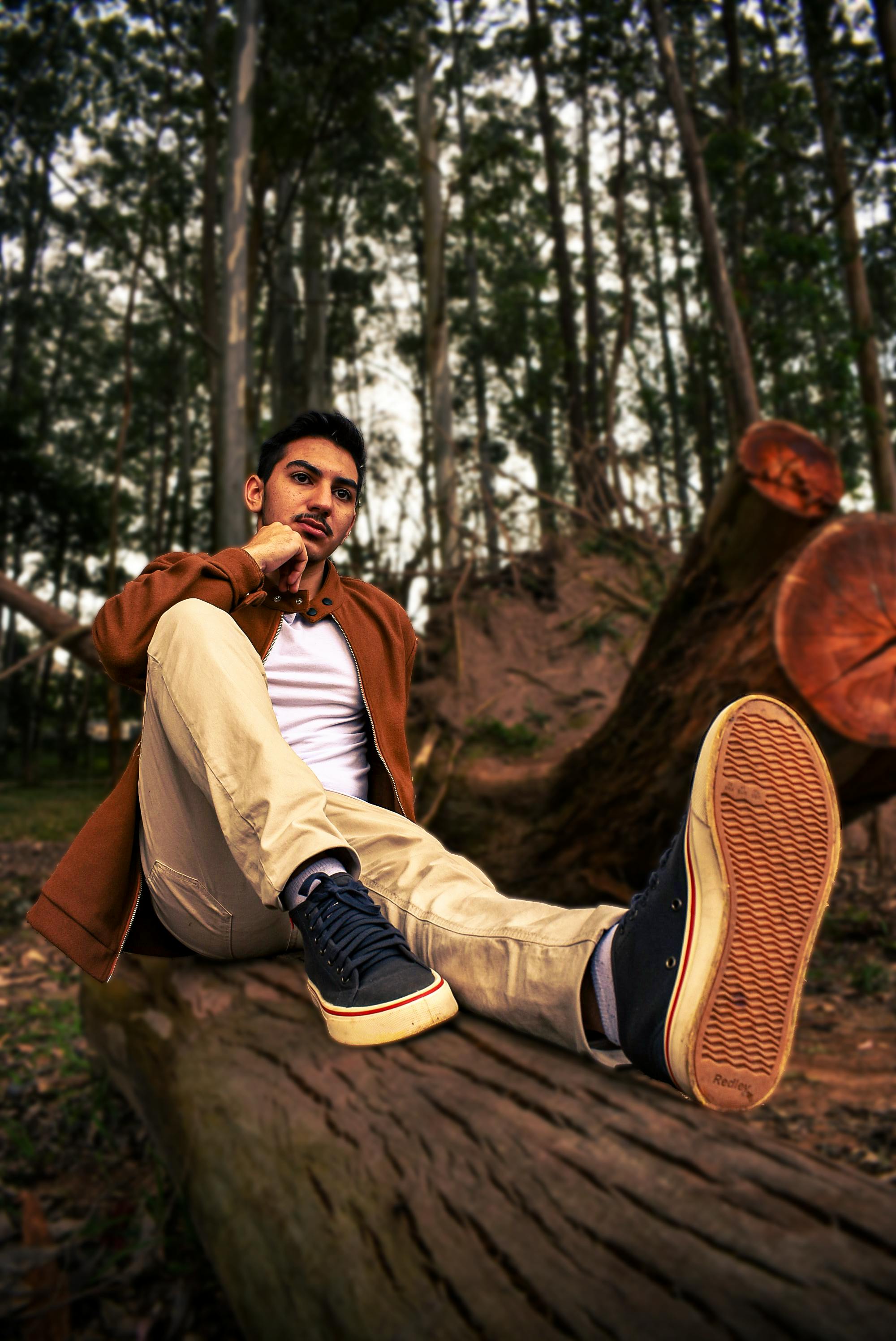 Man Sitting on a Tree Trunk in a Forest and Having Tea · Free Stock Photo