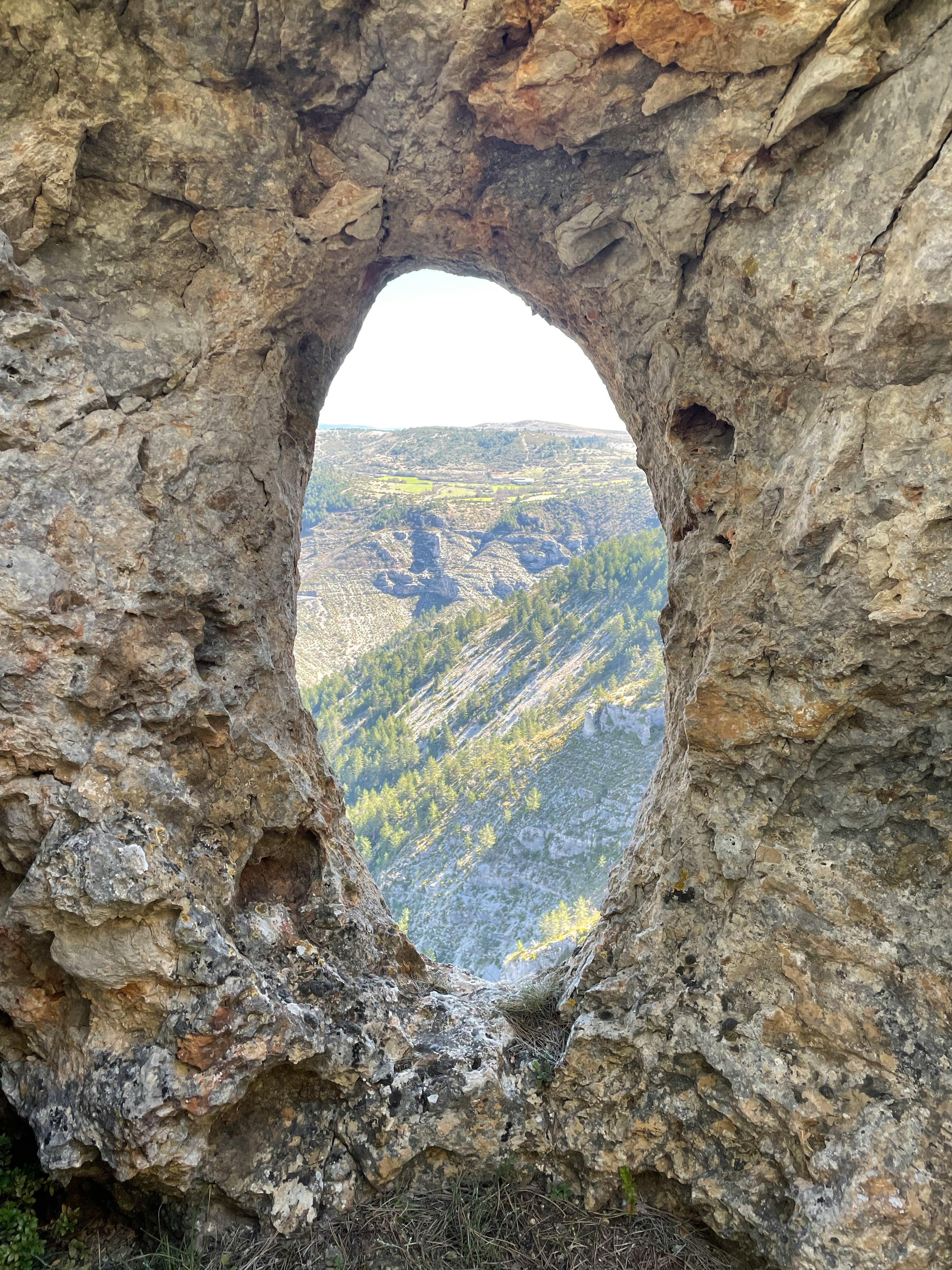 View of Mountains through a Hole in the Rock · Free Stock Photo
