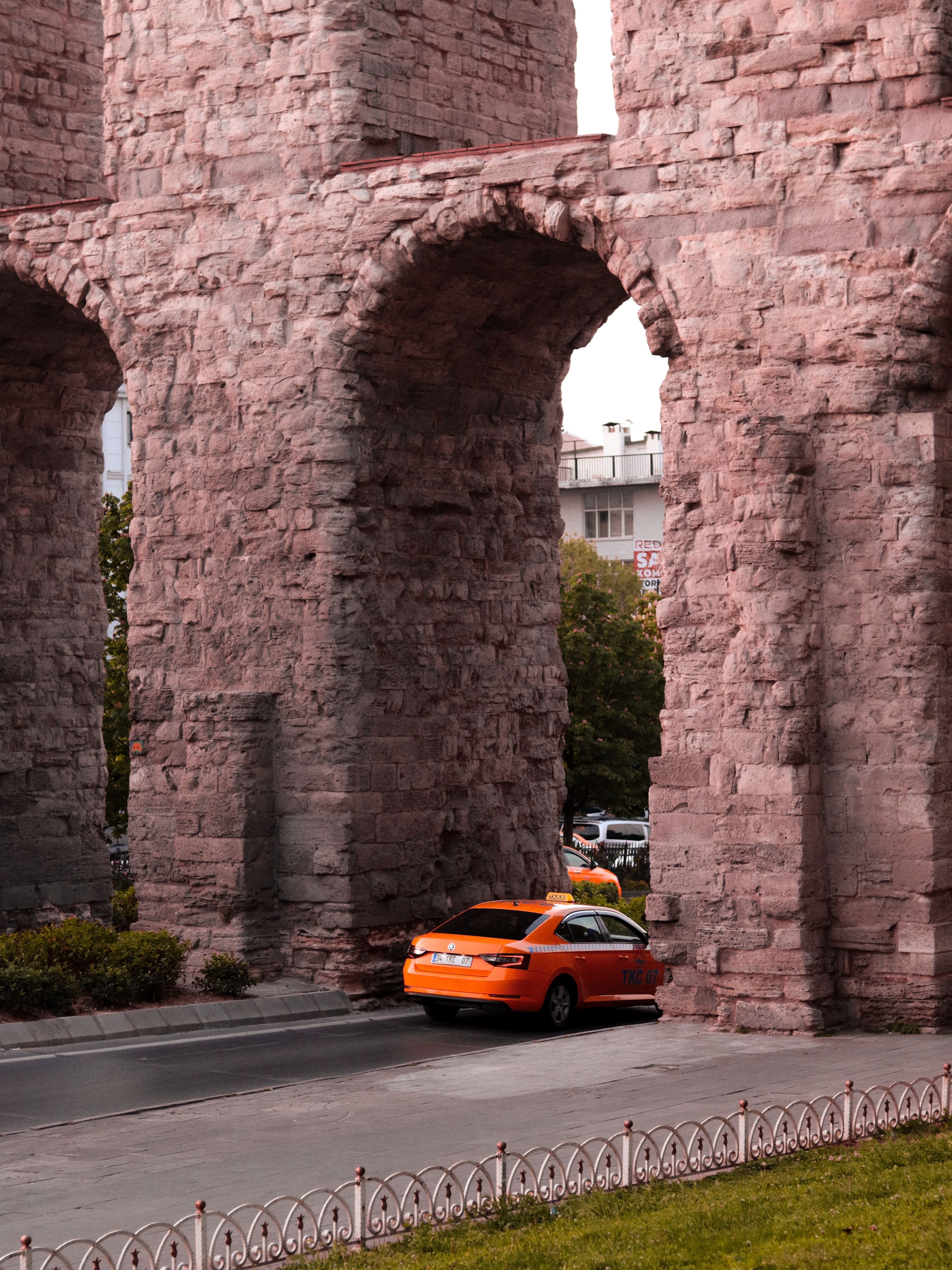 Cars Driving on Road under Stone Old Aqueduct · Free Stock Photo