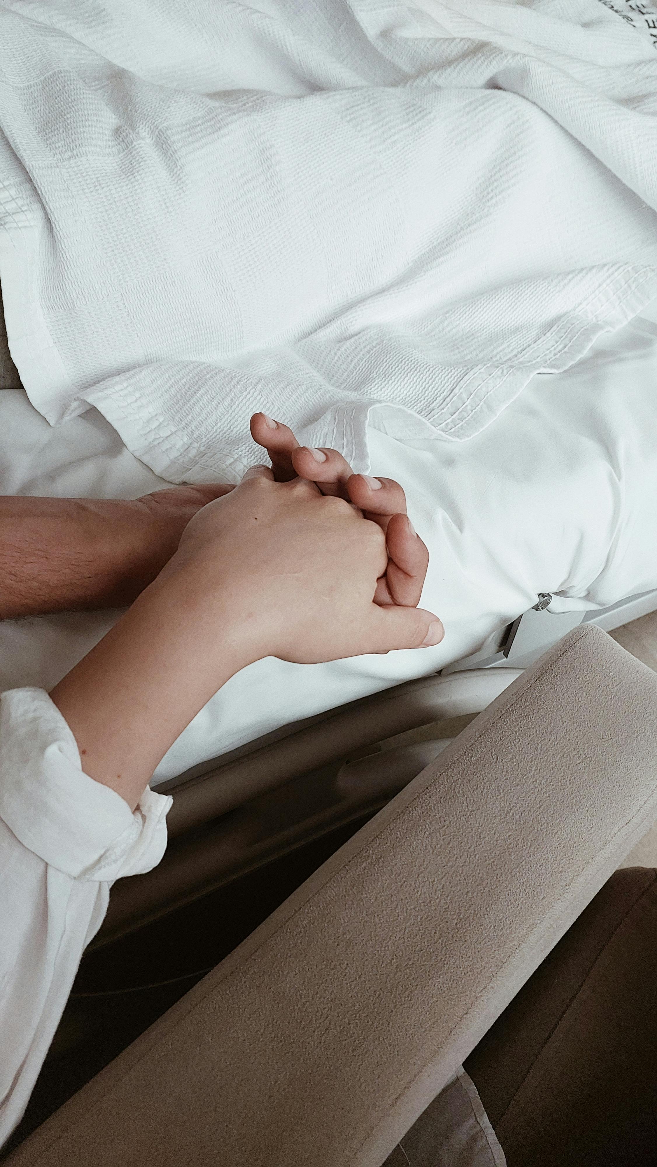 Close-up of Holding Hands in Bed · Free Stock Photo