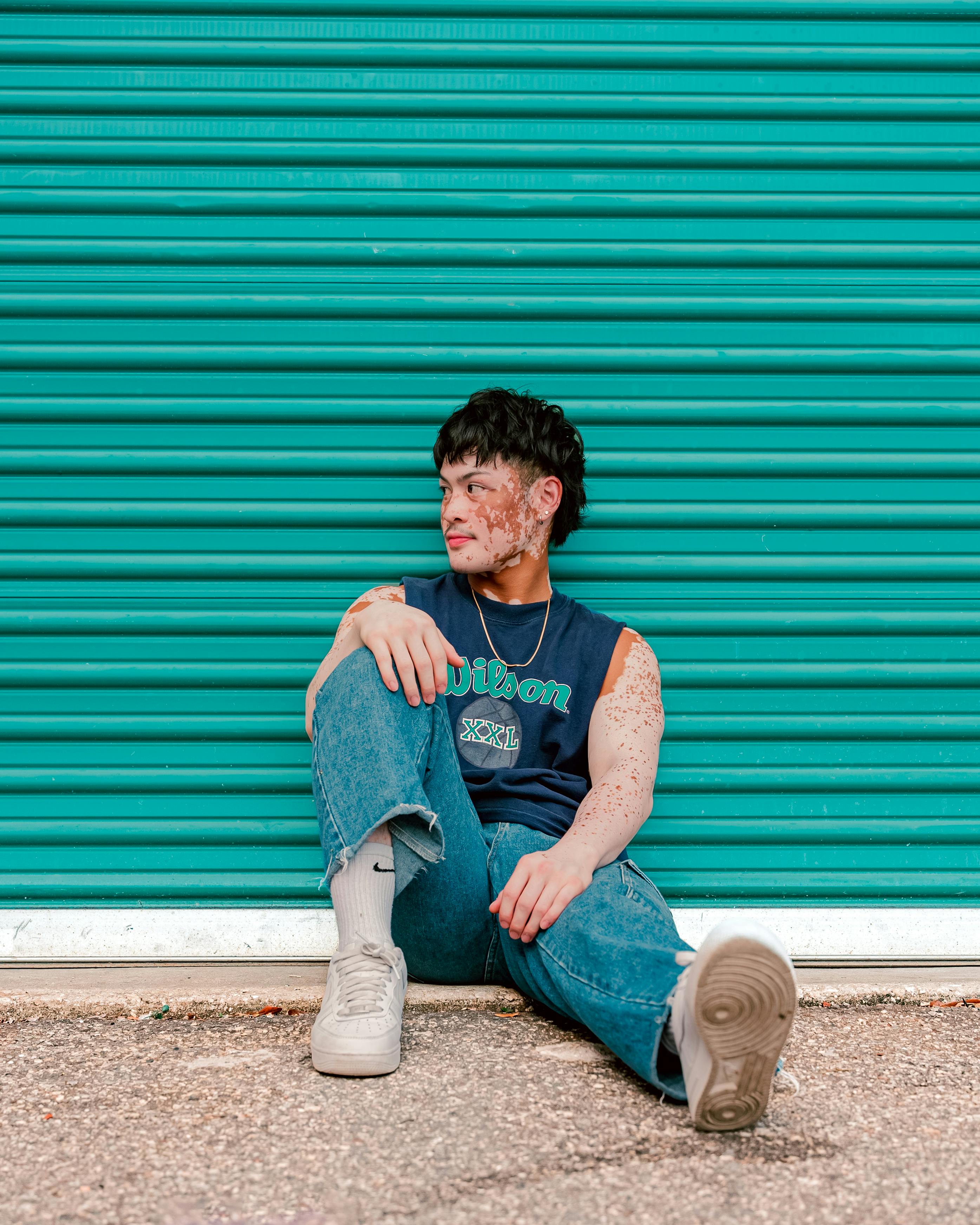 Man Sitting and Posing by Wall · Free Stock Photo