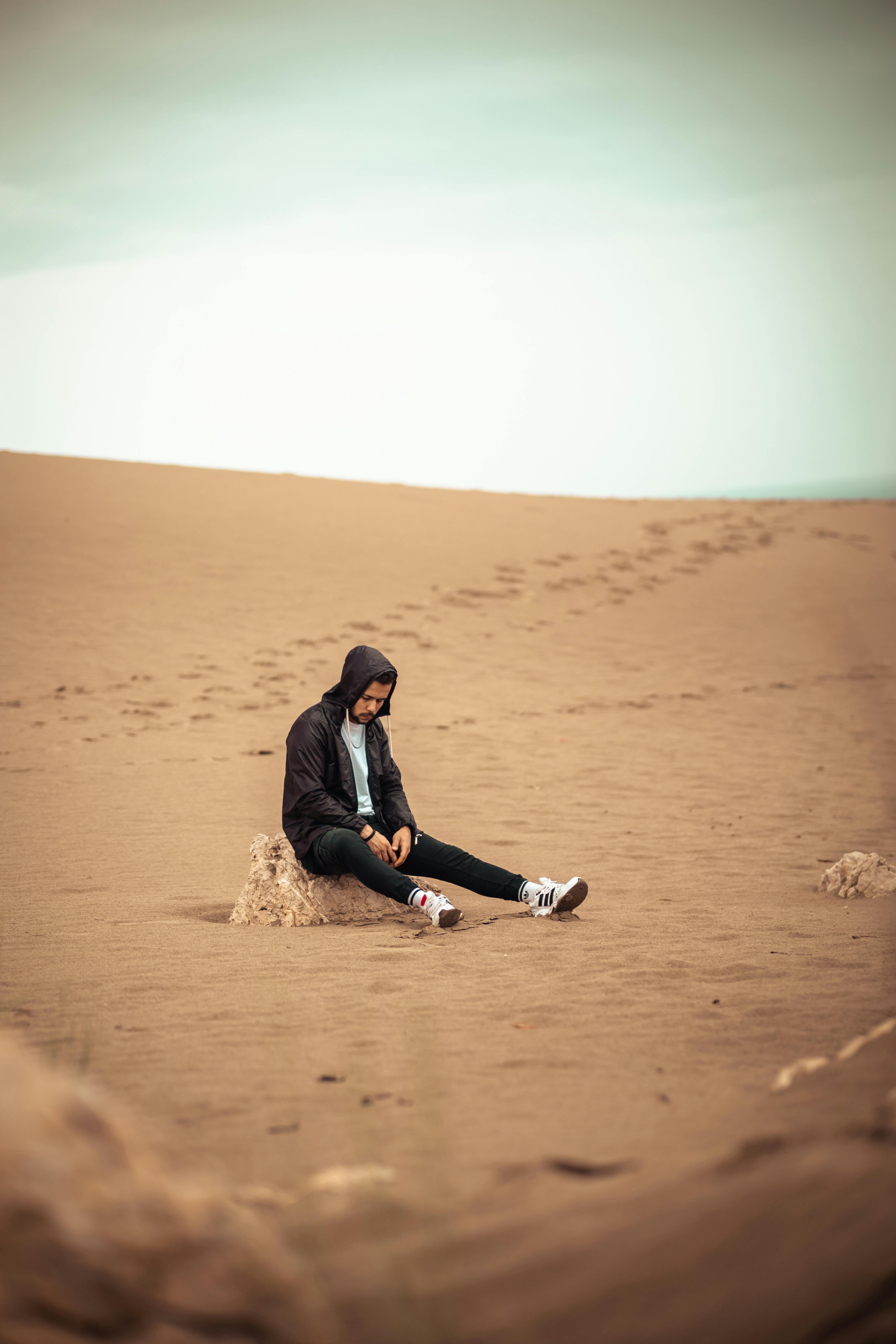 Man Sitting amid Desert · Free Stock Photo