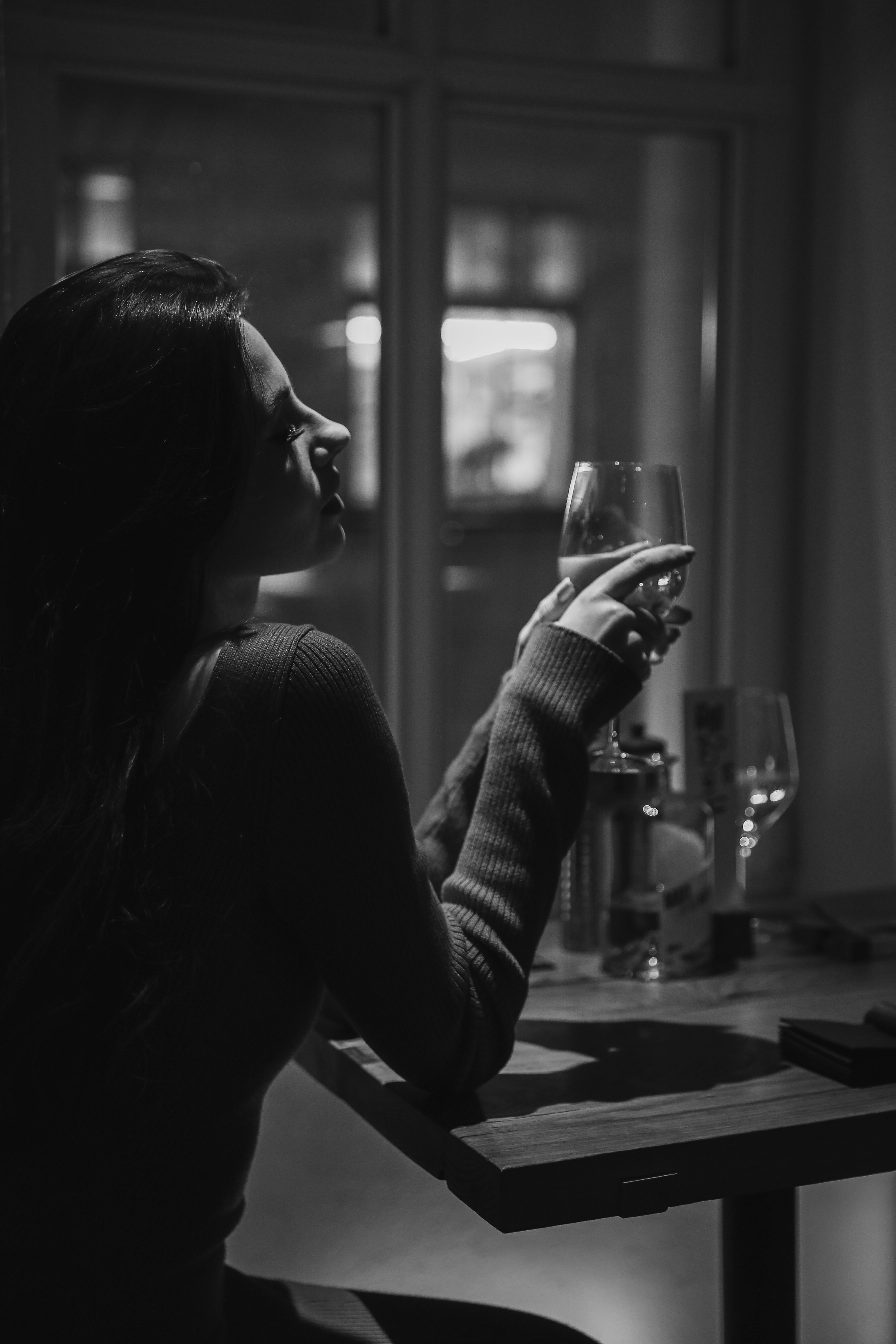 A woman sitting at a table with a glass of wine · Free Stock Photo