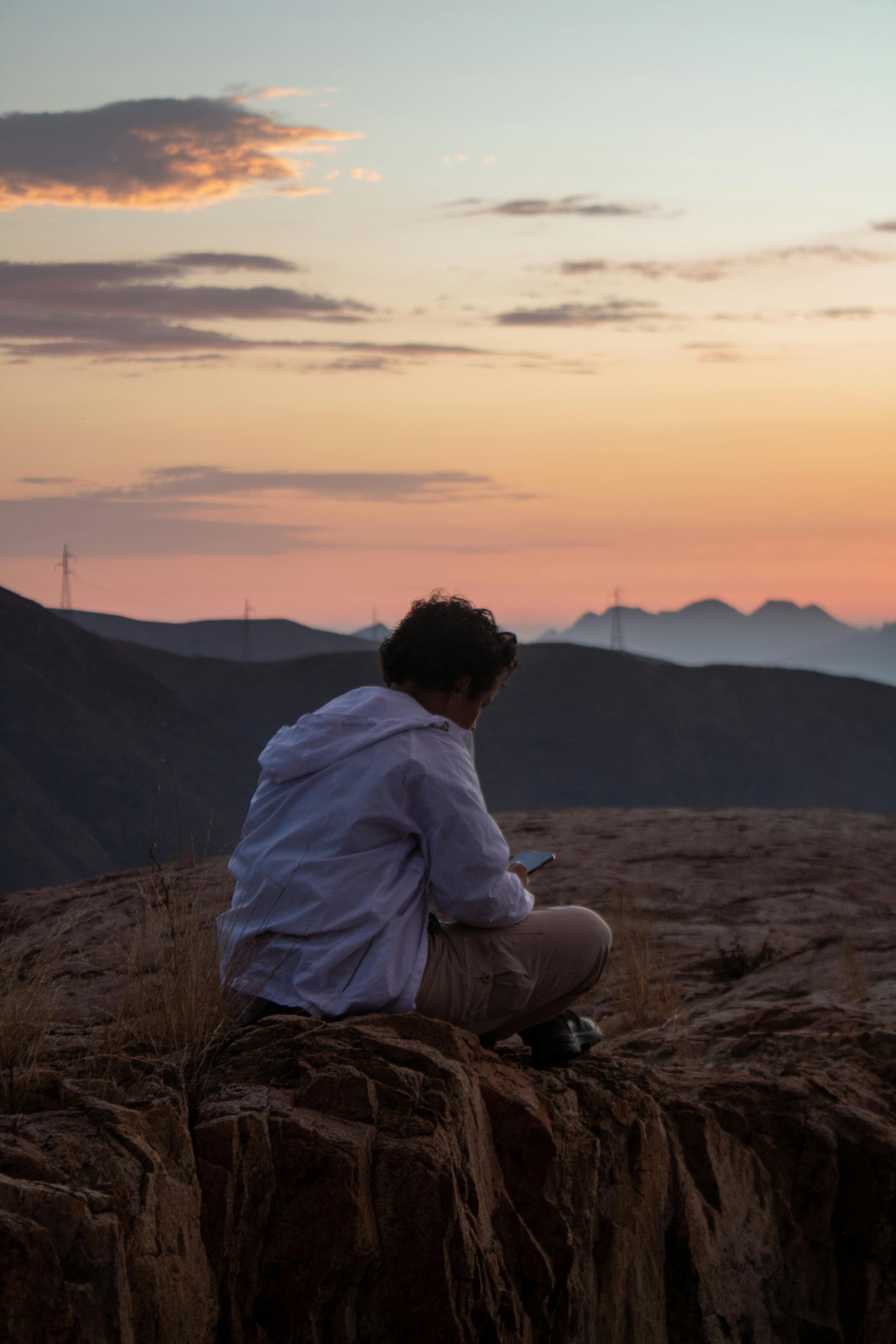 Man Sitting on a Rock and Looking at a Landscape at Sunset · Free Stock ...