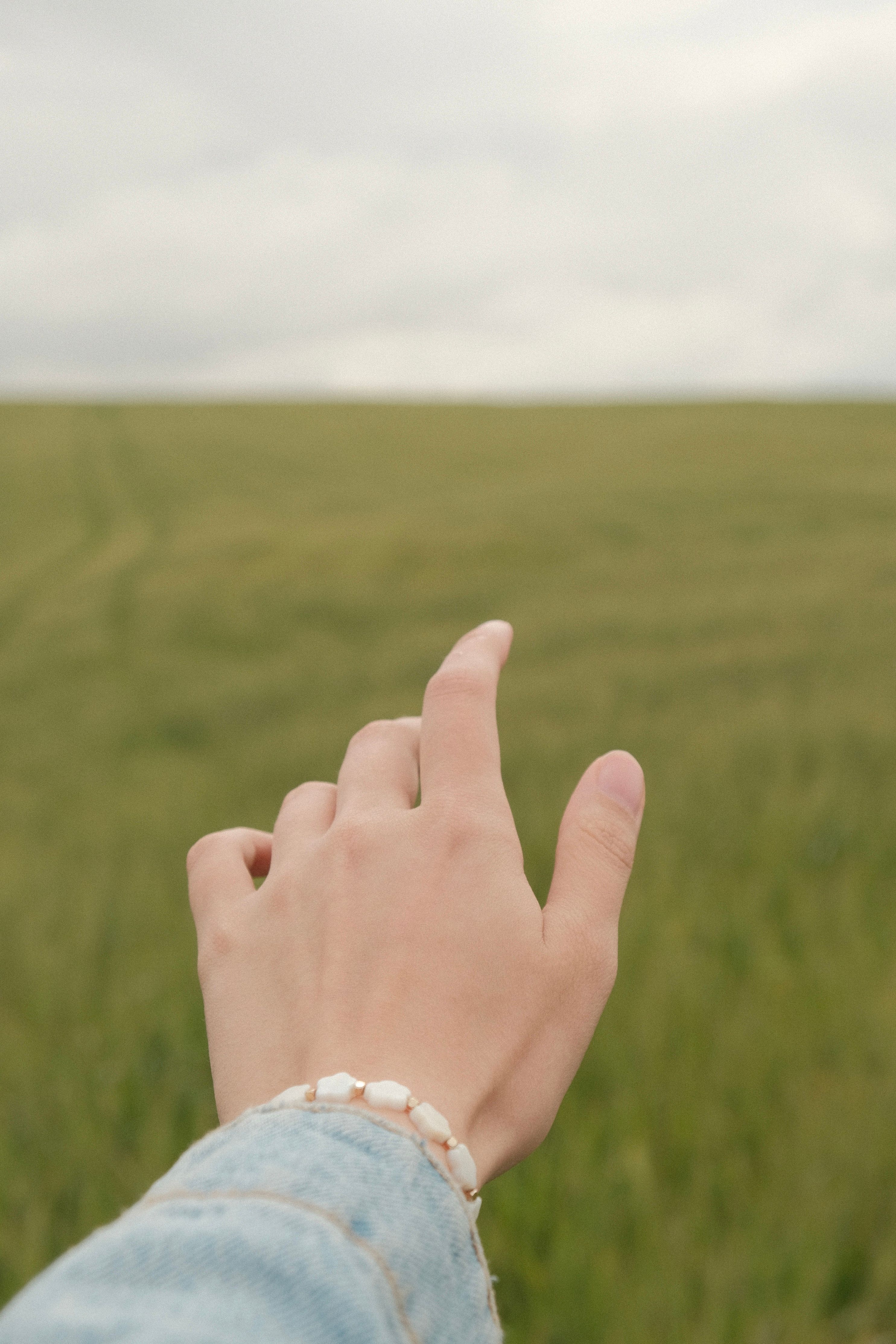 Hand over Green Field · Free Stock Photo
