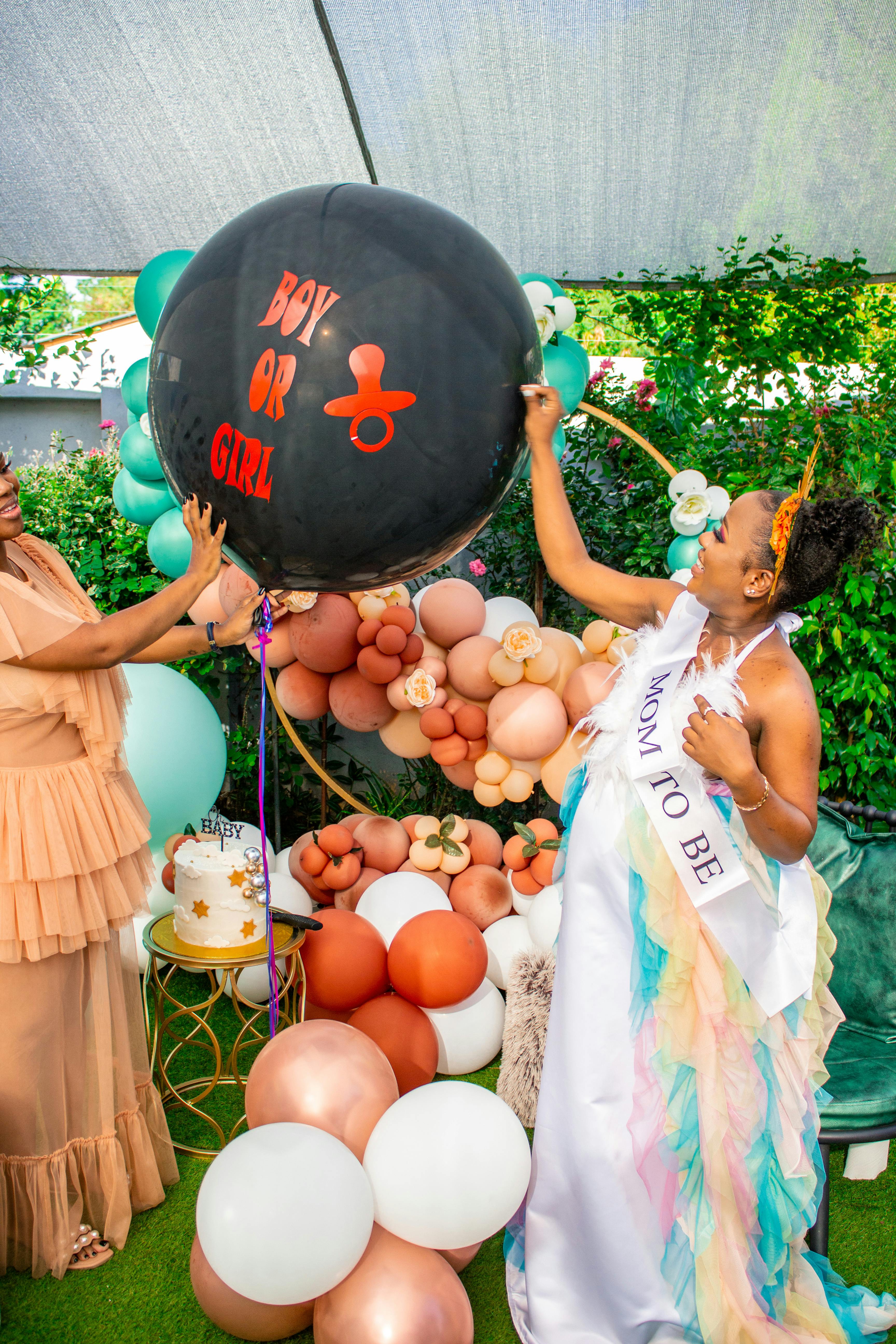 Two women holding balloons and one holding a balloon · Free Stock Photo