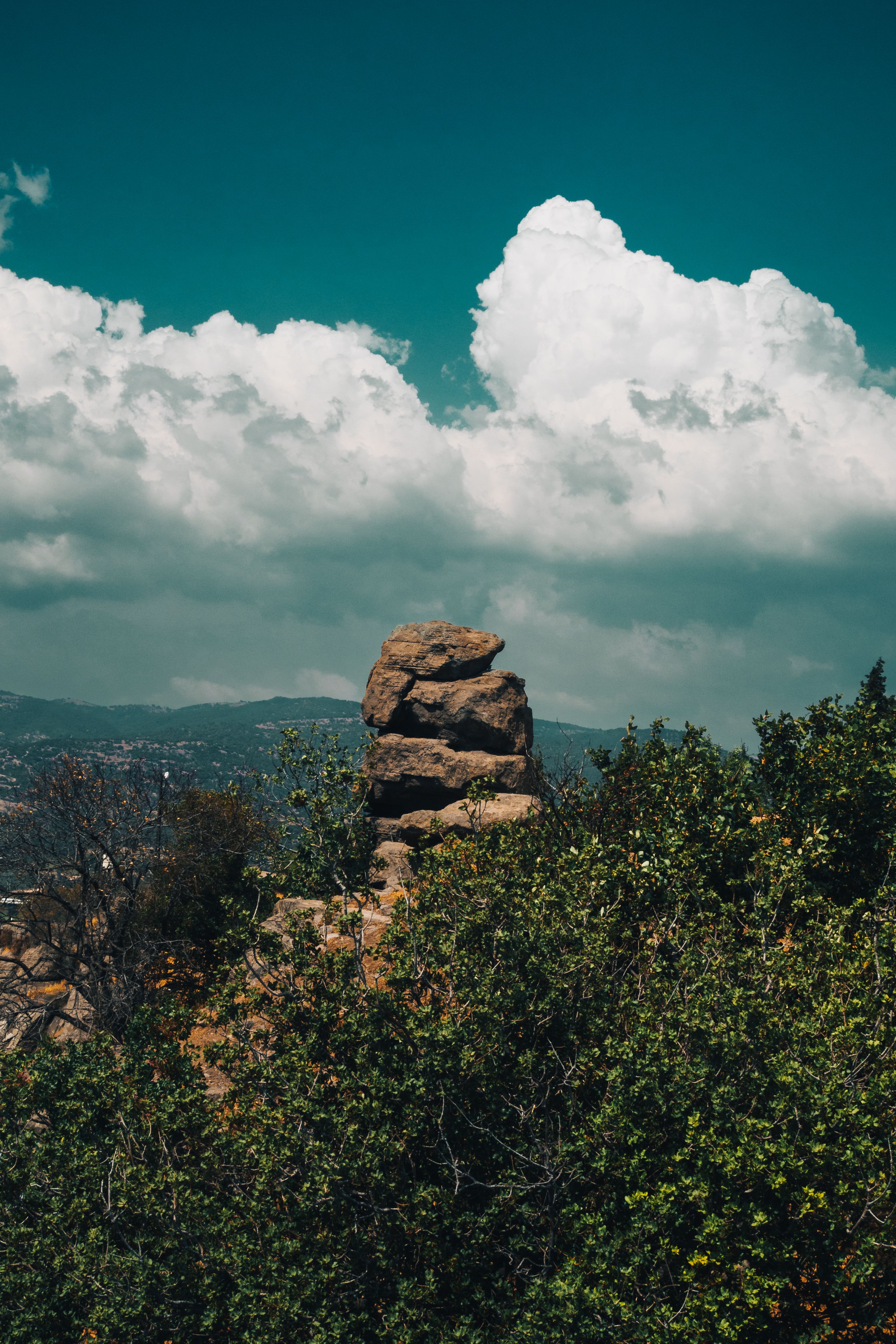 A rock formation with clouds in the sky · Free Stock Photo