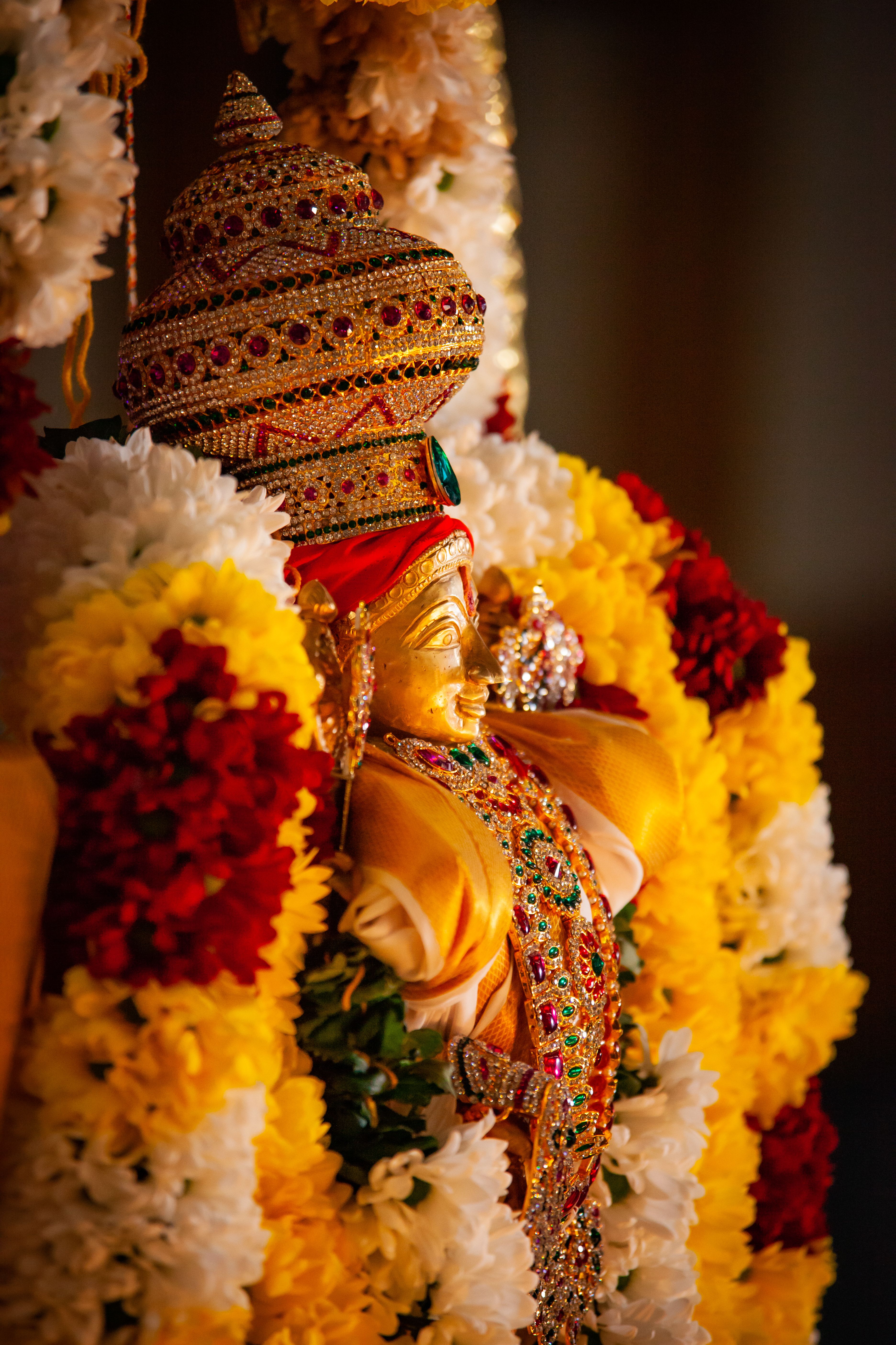 Golden Statue Covered in Flowers and Jewelry · Free Stock Photo