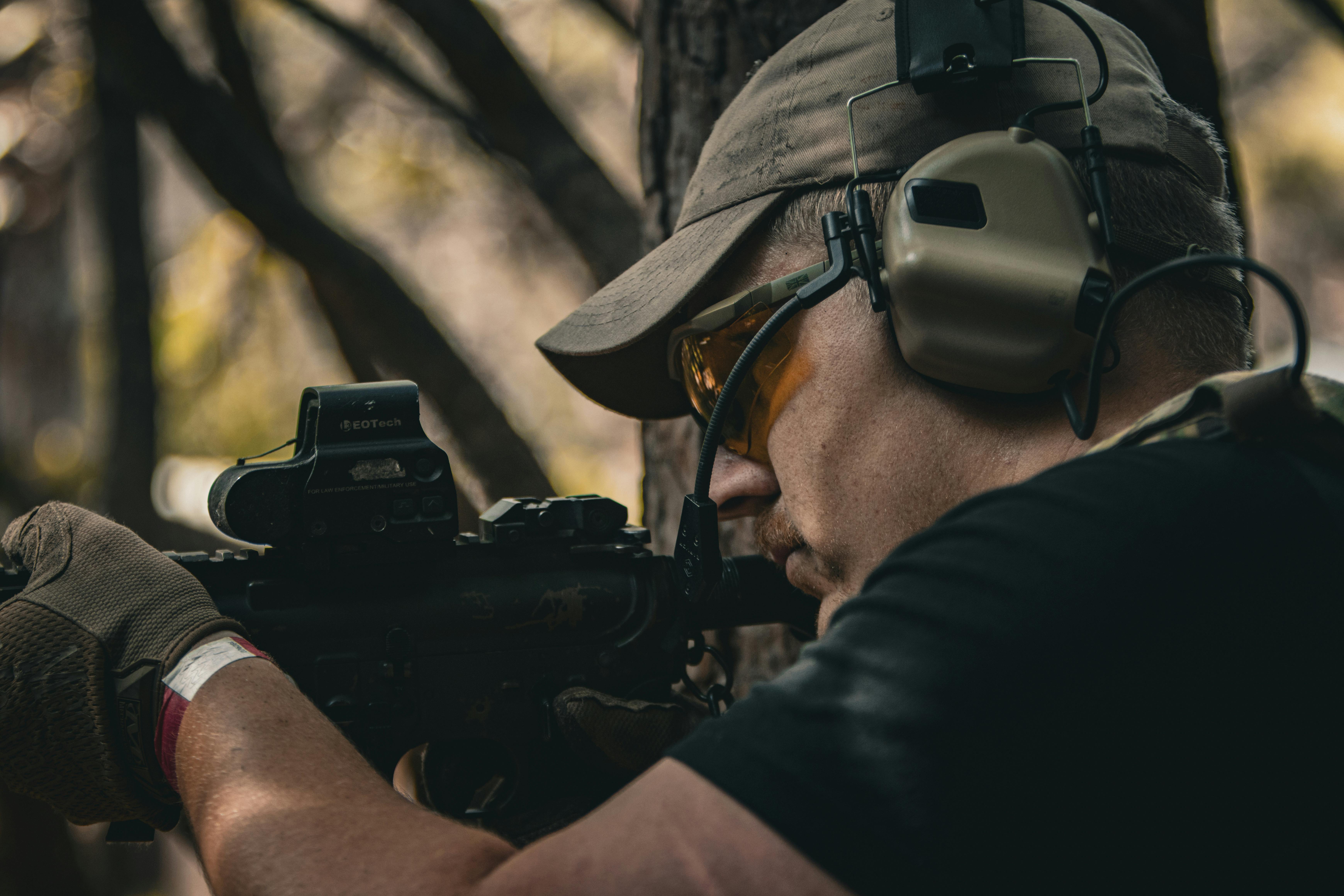 Man in Tactical Protective Headset and Eyeglasses Aiming His Rifle for ...