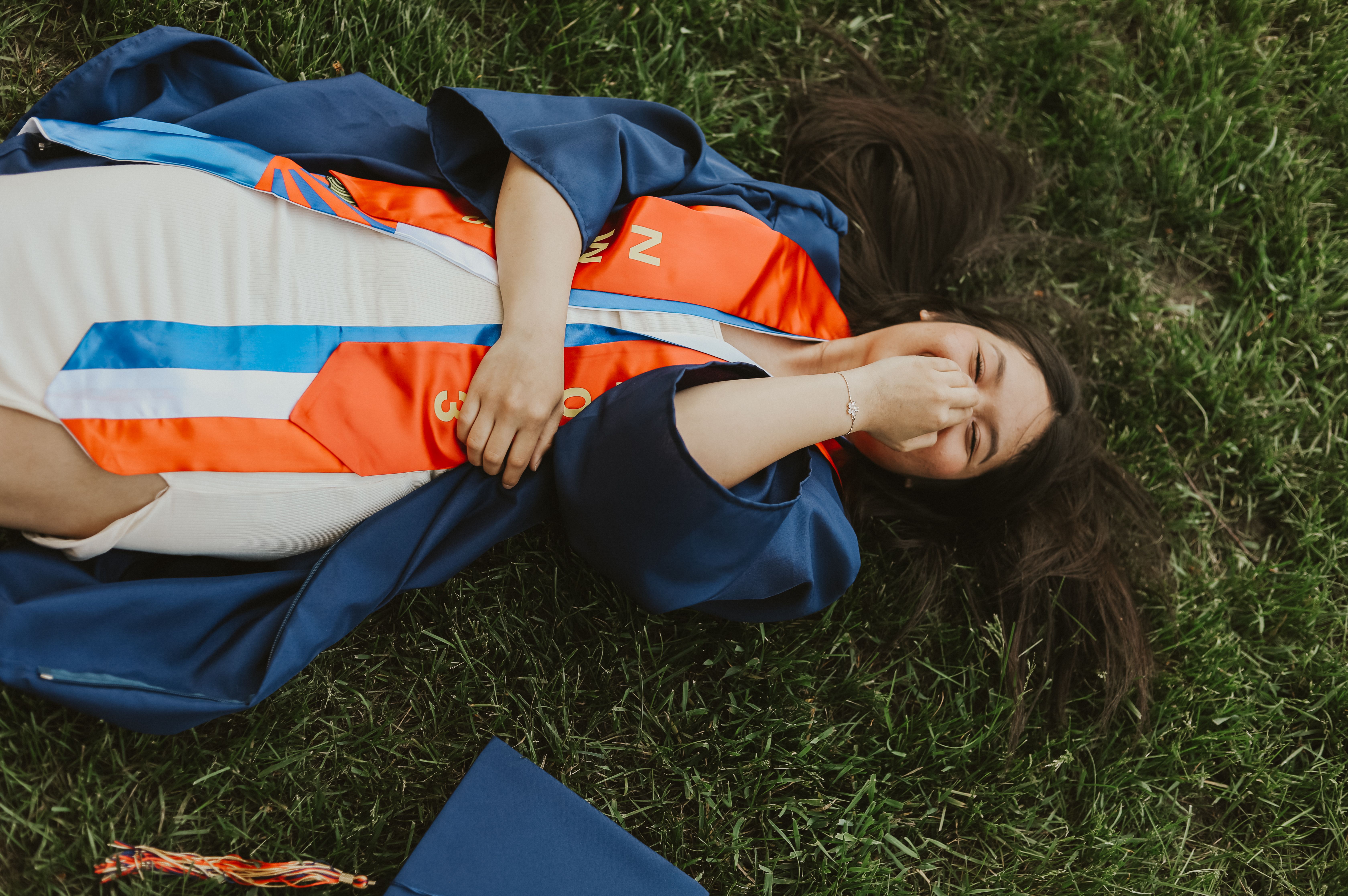 Young Woman in a Graduation Gown Lying on the Ground and Smiling · Free ...
