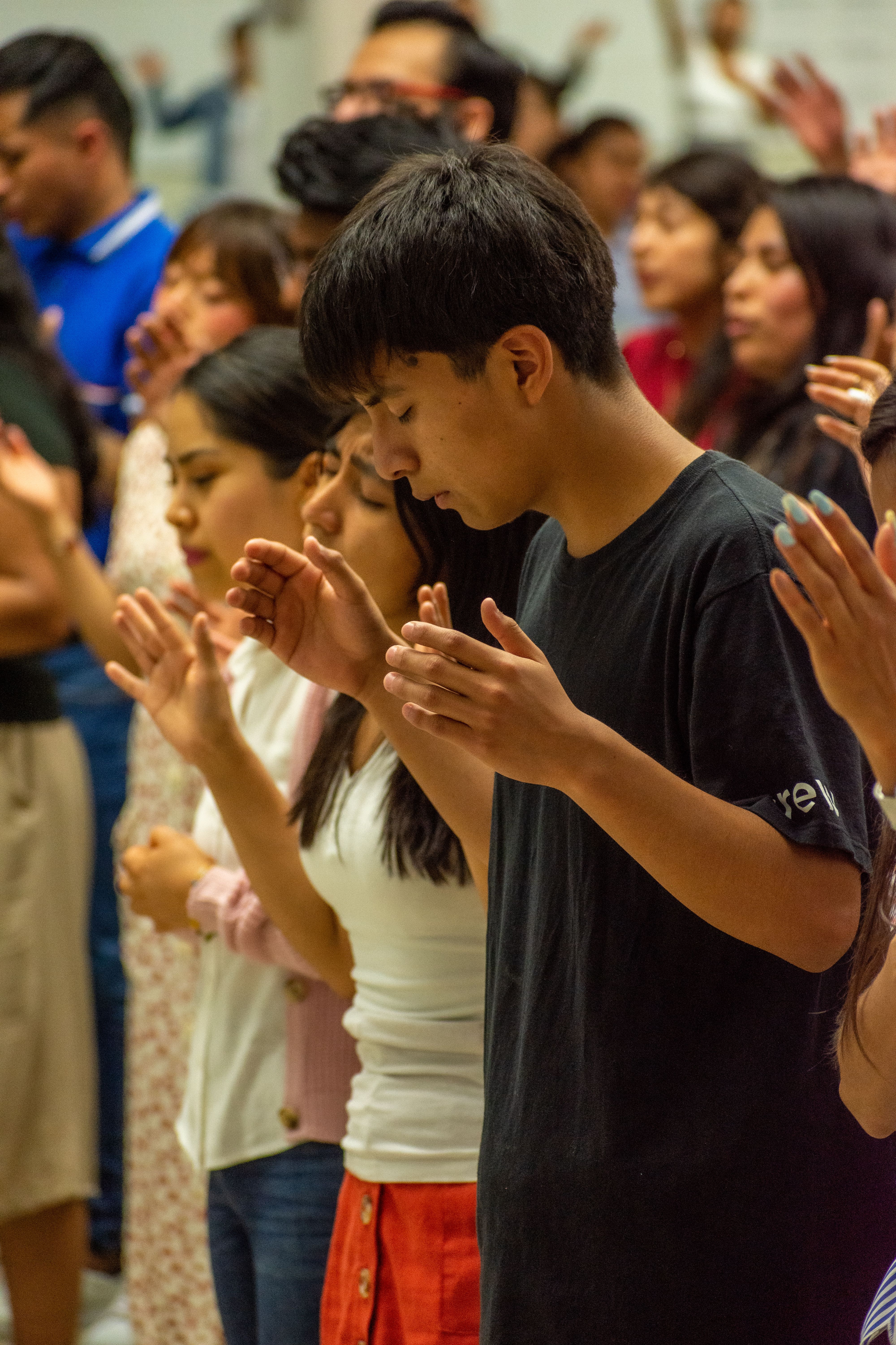 A group of people standing in a room clapping · Free Stock Photo