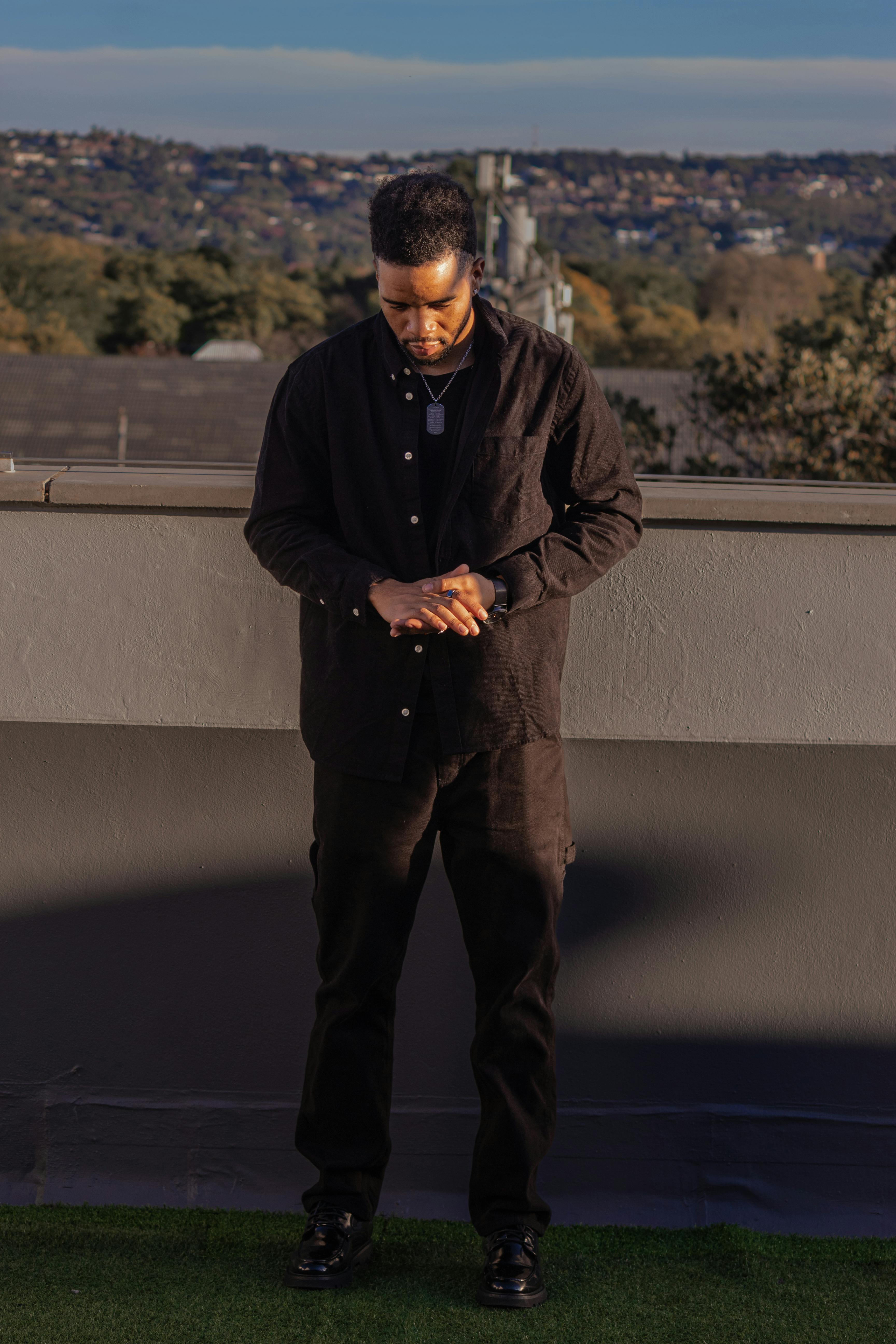 Man on a Roof, Looking at His Hands · Free Stock Photo