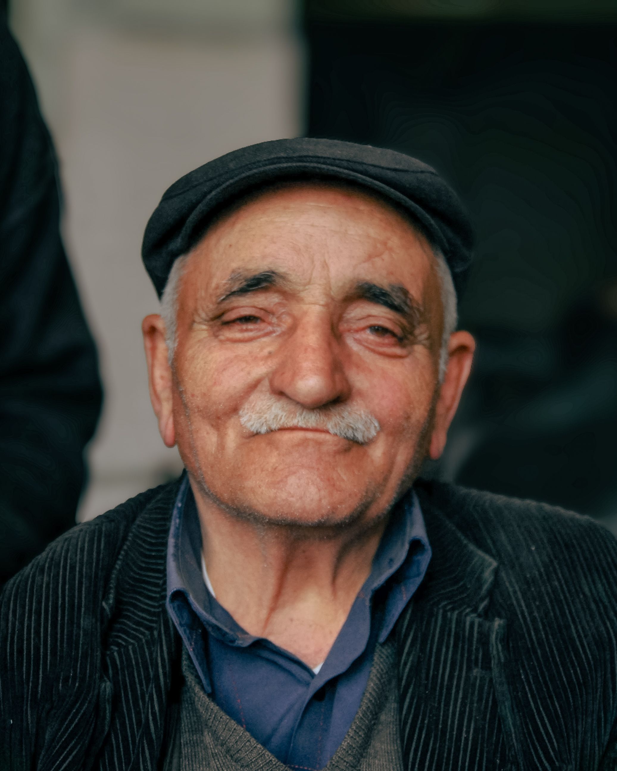 Smiling Man with Black Mustache Sitting with Friends by Brick Wall ...