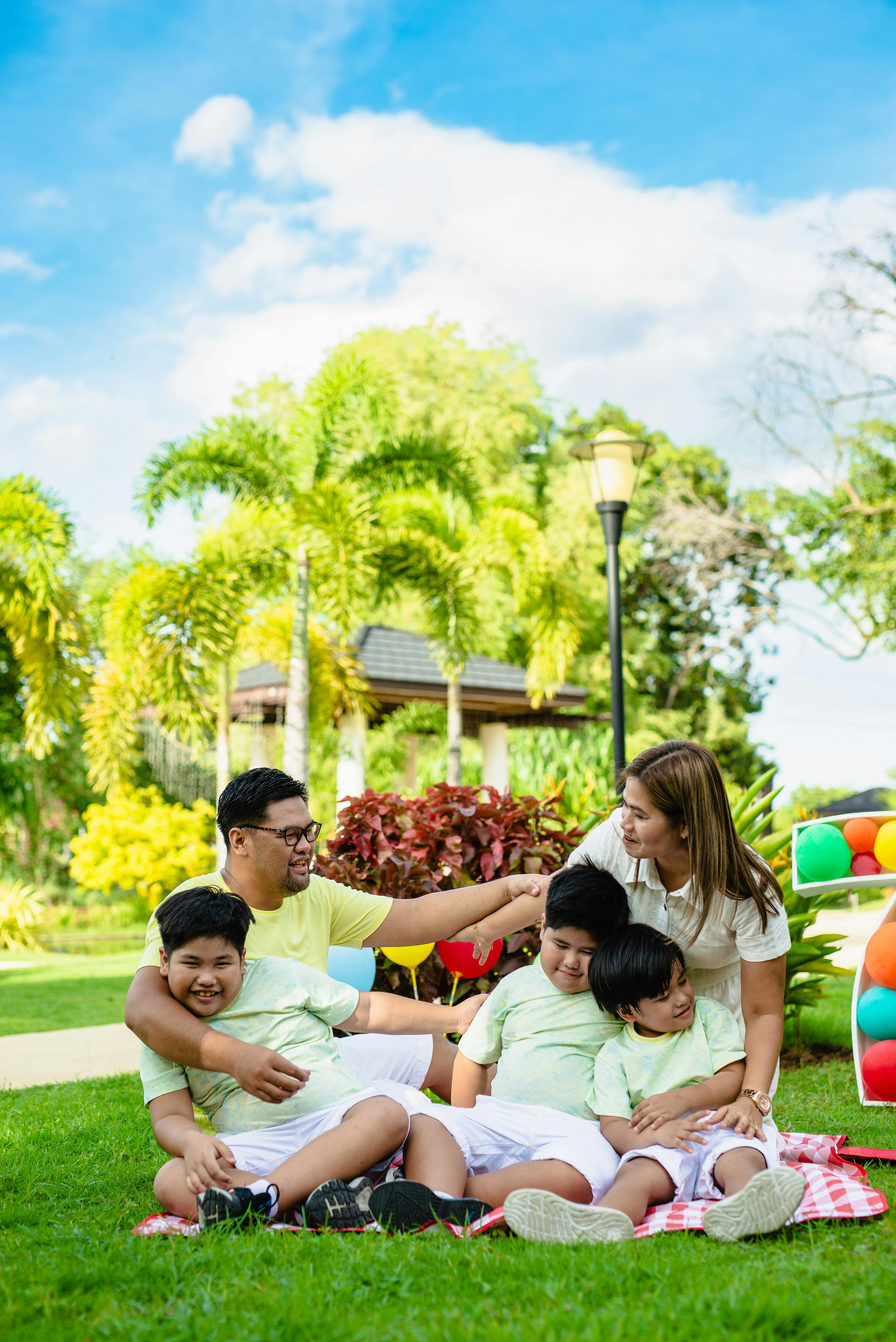 A Family with Three Kids Posing for a Picture in a Park · Free Stock Photo