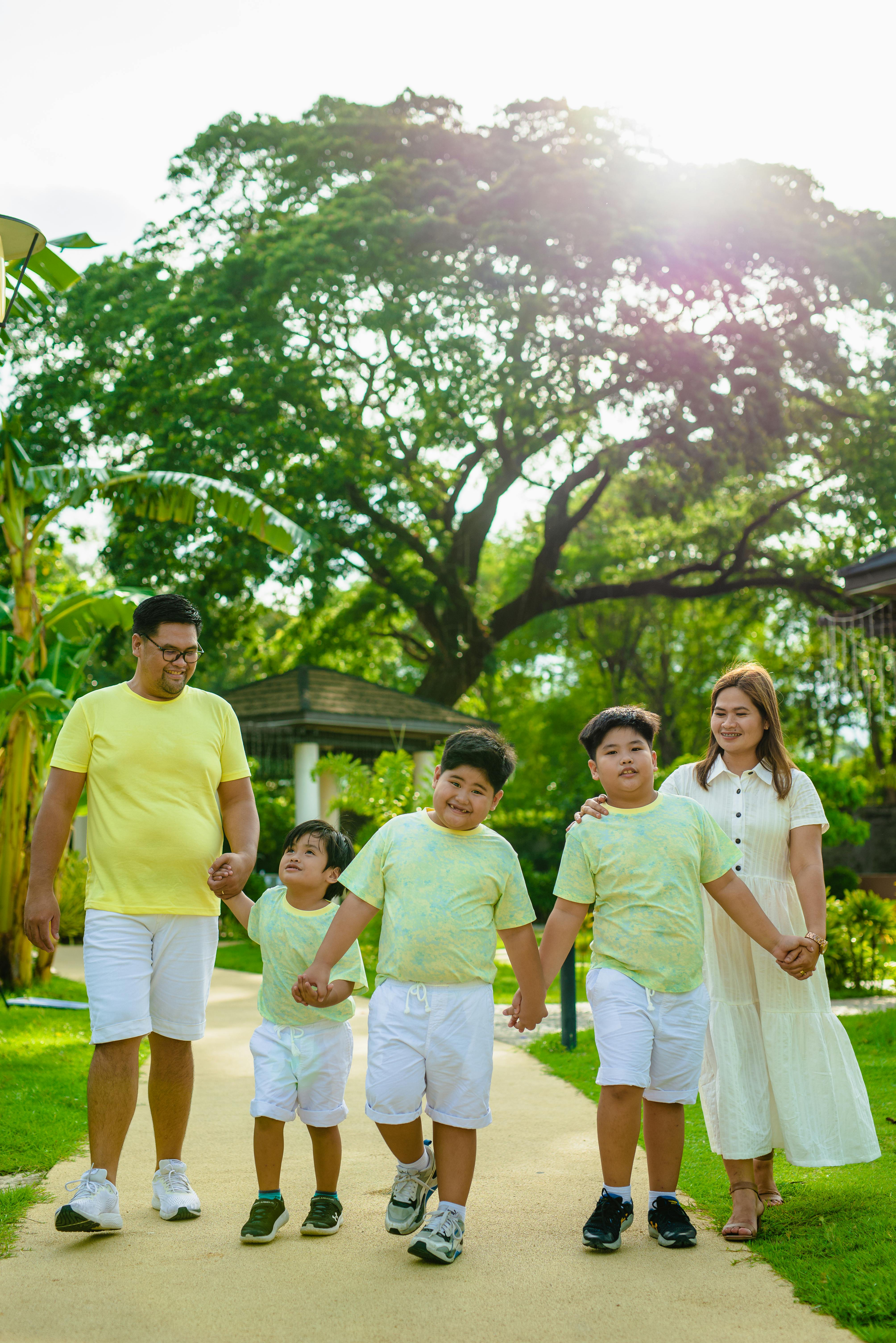 A Family with Three Kids Posing for a Picture in a Park · Free Stock Photo